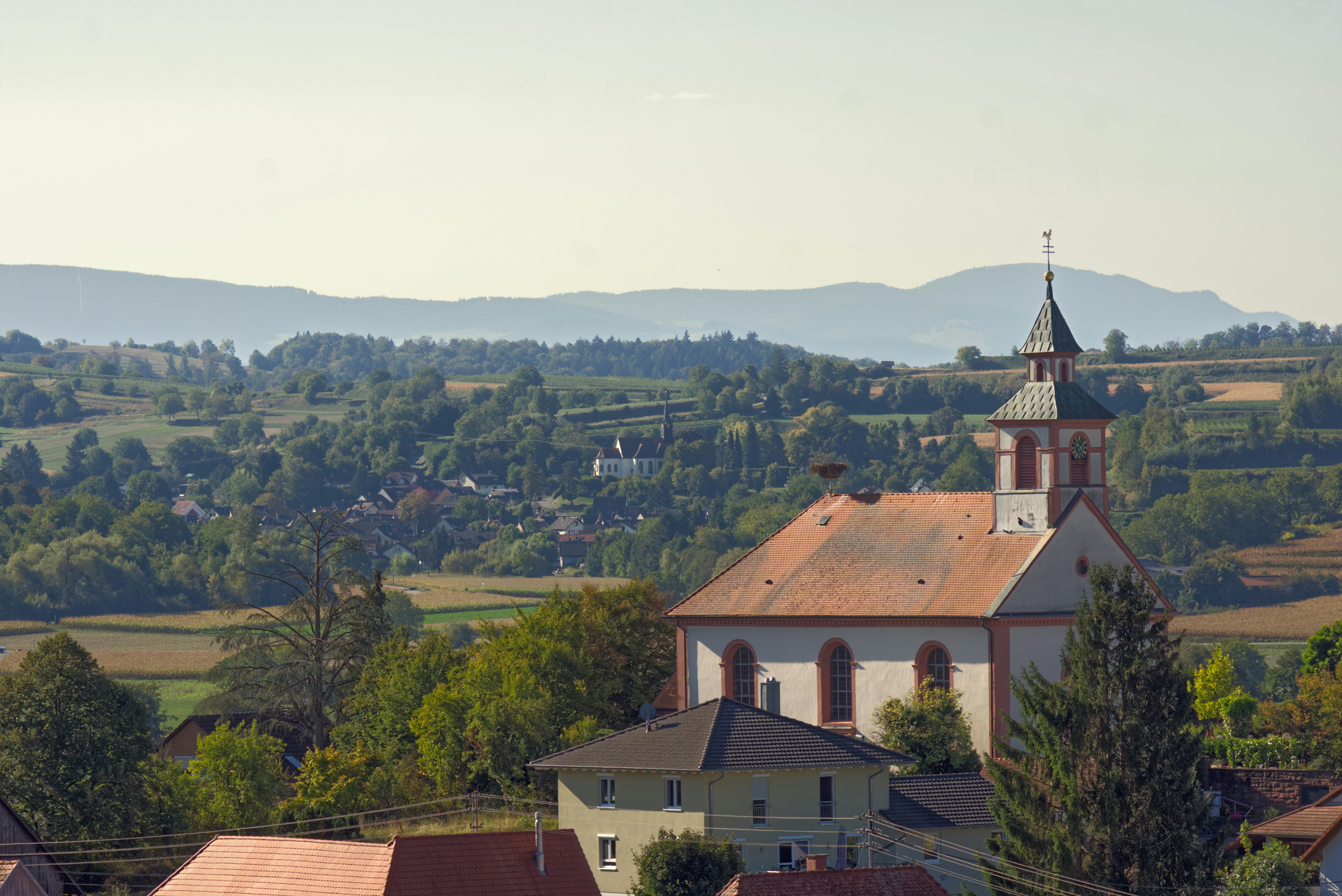 Village Church Steeped in Golden Light Over Rolling Hills