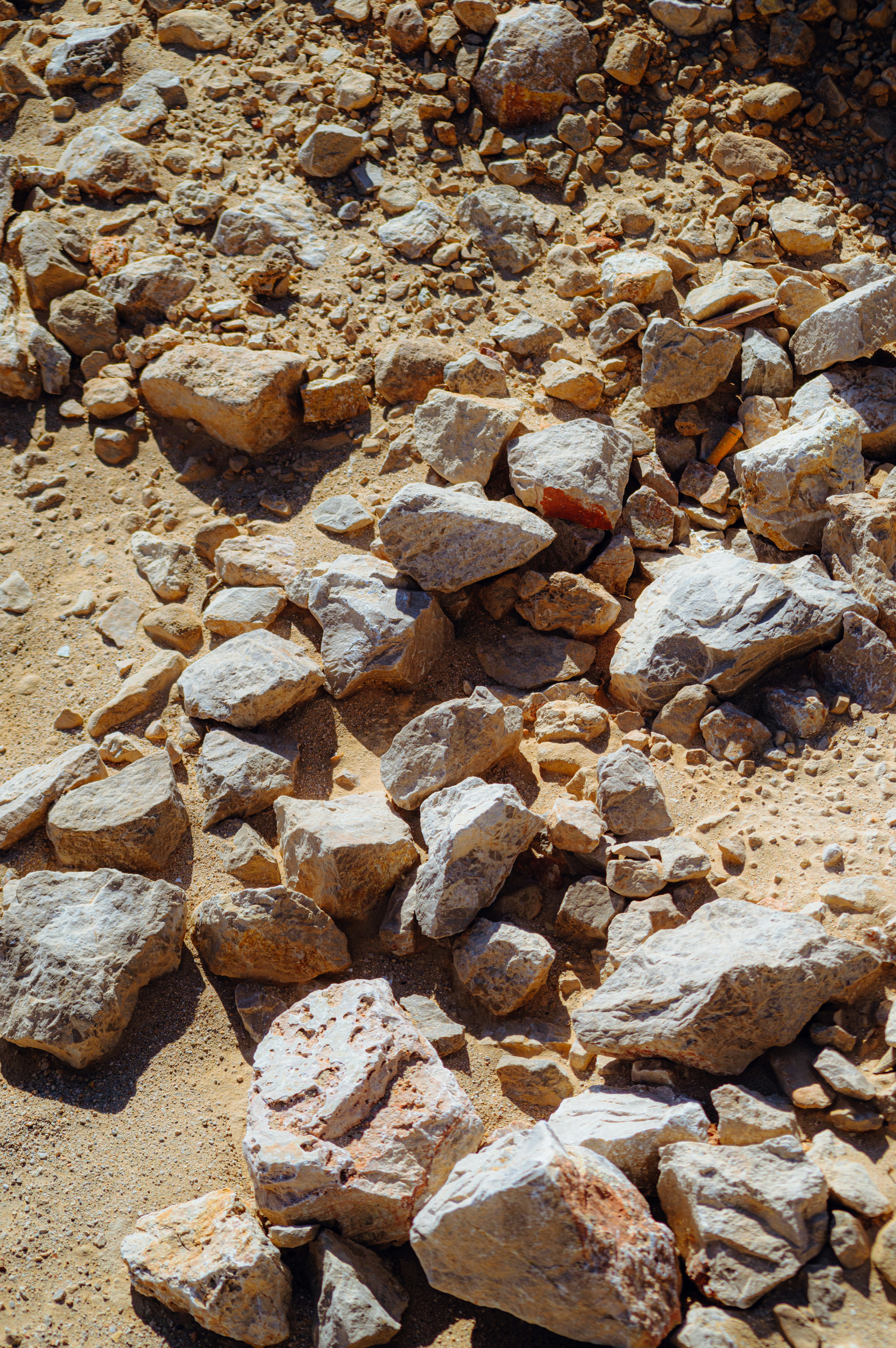 Rugged cascade of sunlit stones along a dusty slope