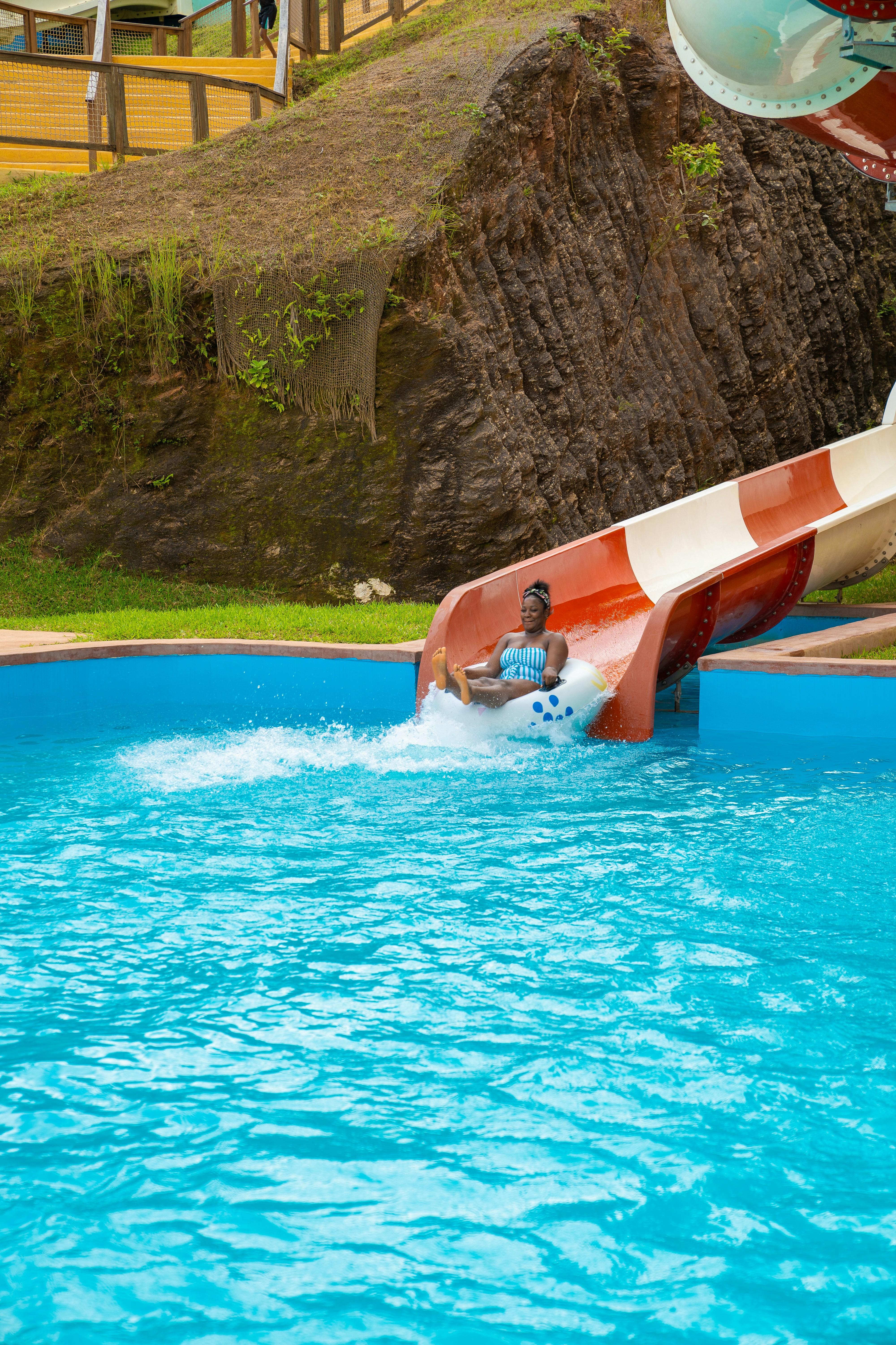 Slipstream Smile: A rider rides the blue wave down the red-and-white chute