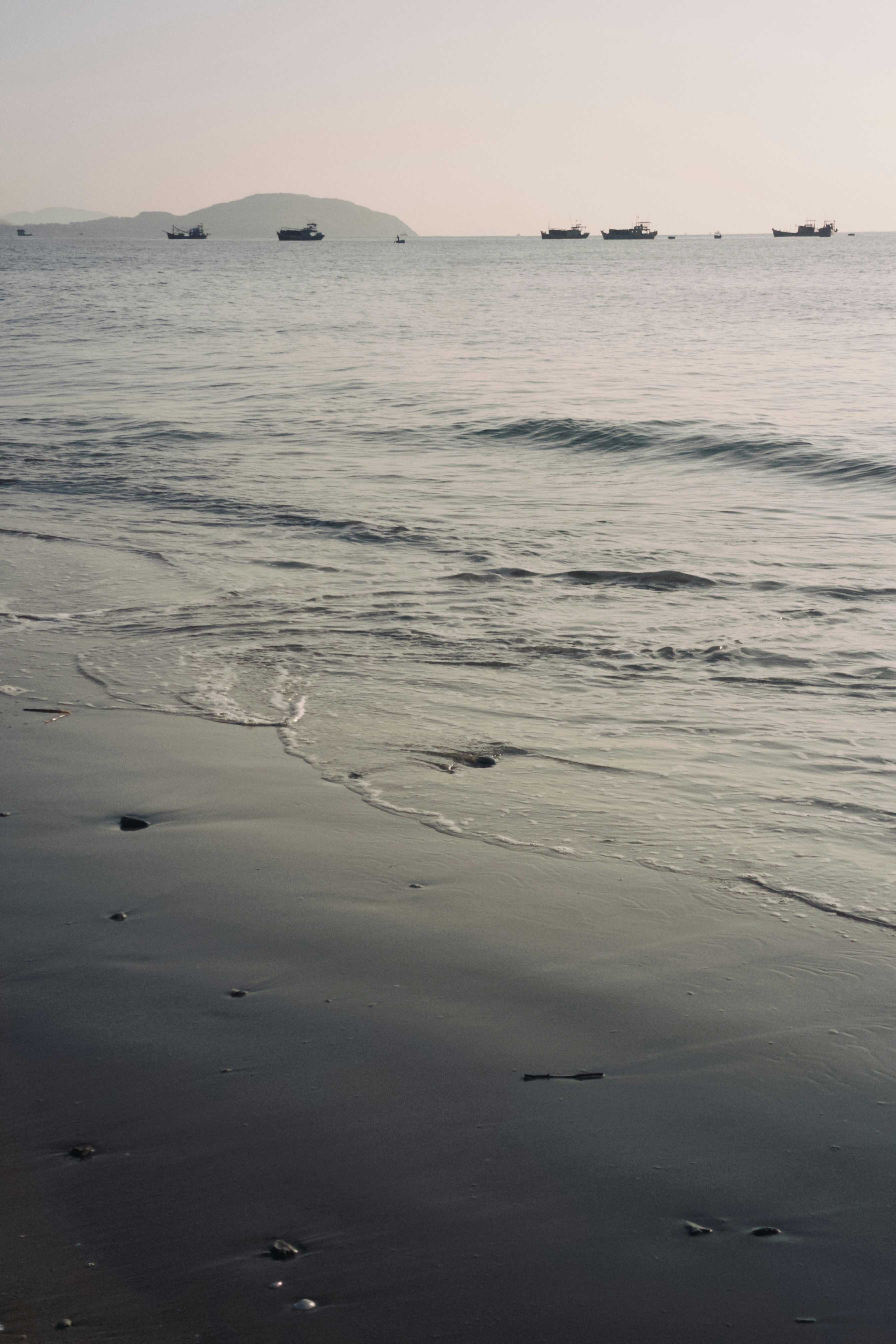 Silent Horizon: Boats at Dusk Over a Quiet Shore