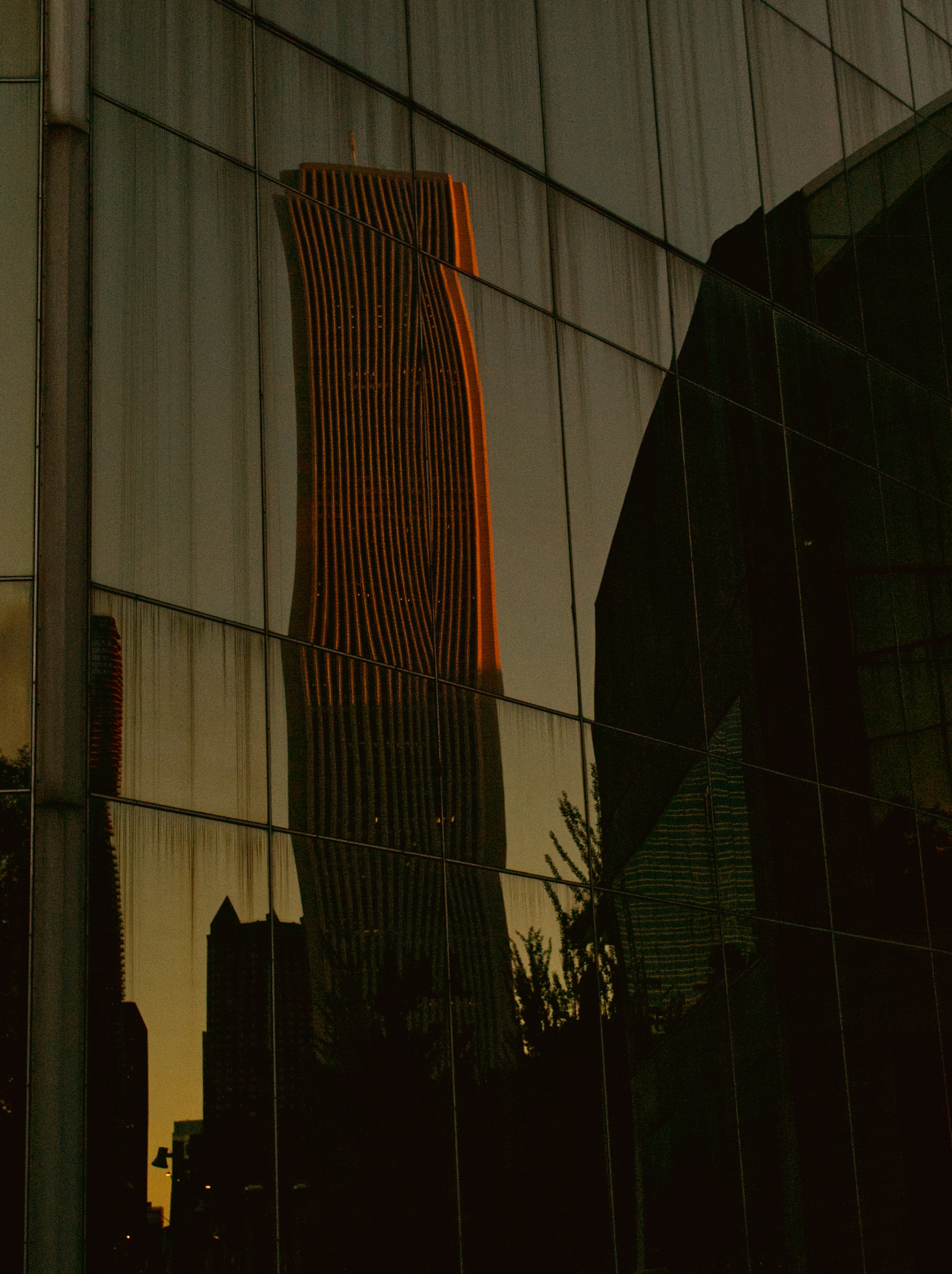 Glass Facade Echoes a Copper-tinted Skyline