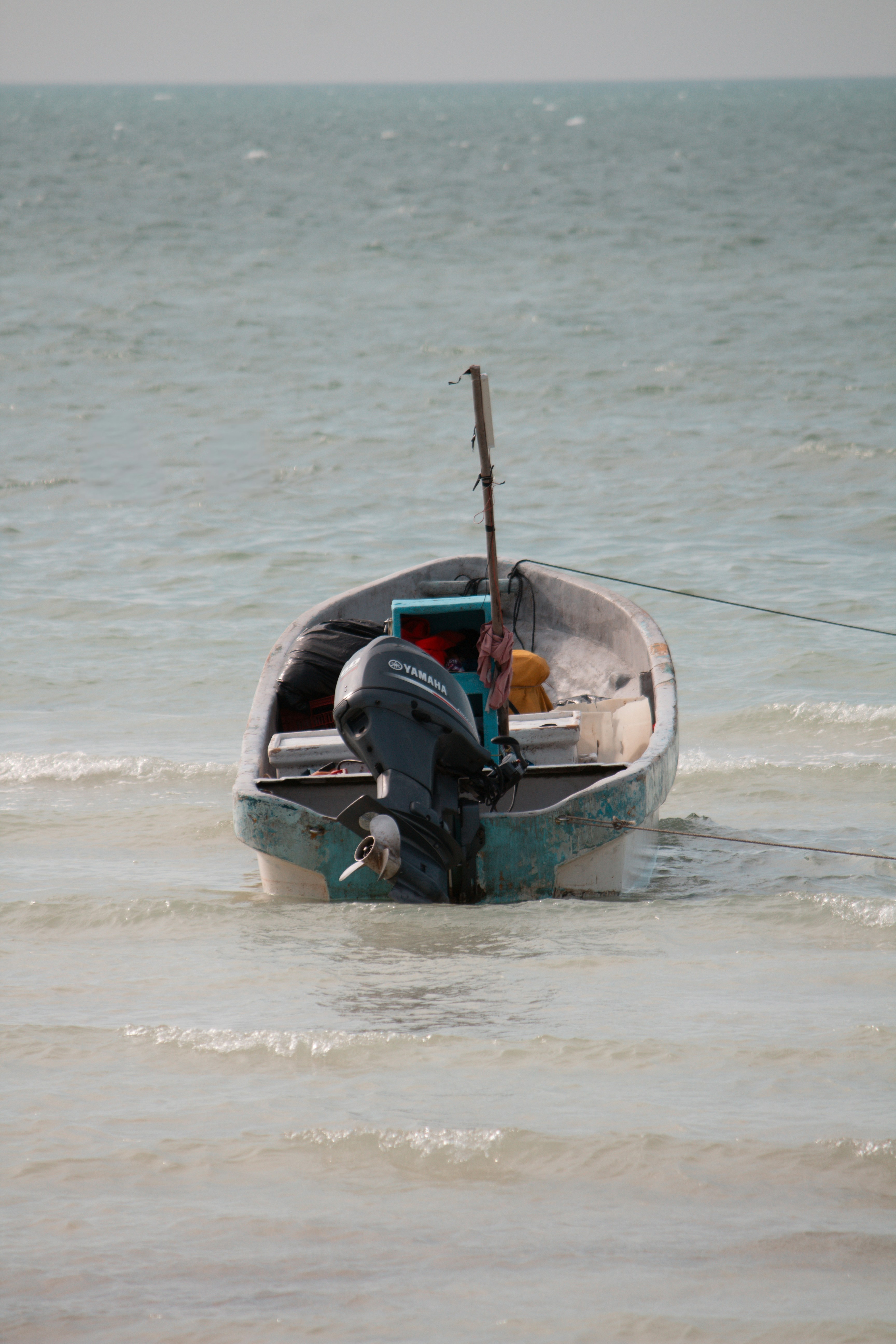 Toward Silence: A Small Outboard Boat Waiting at the Shore