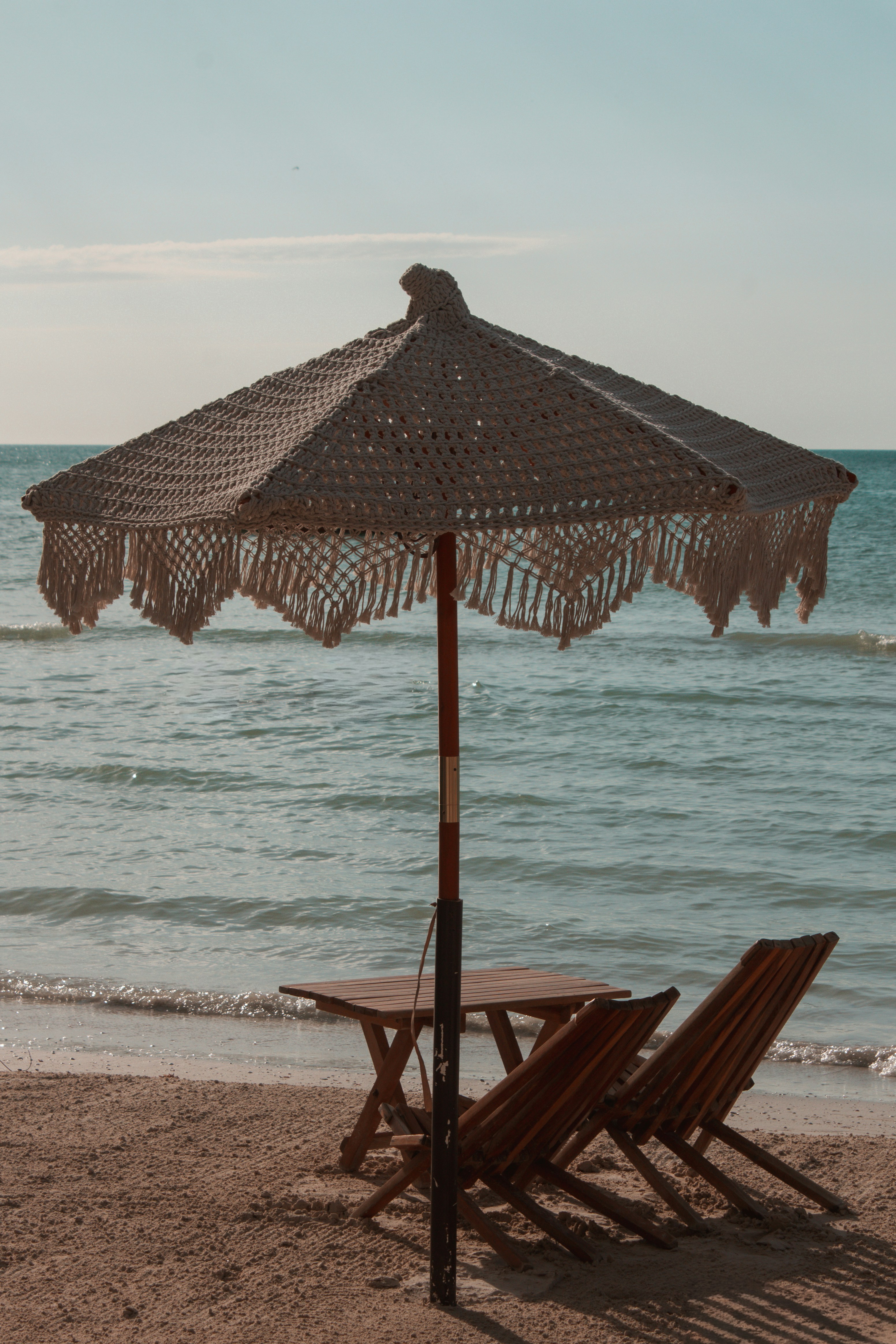 Sunlit Beach Parasol and Reclining Chairs by the Sea