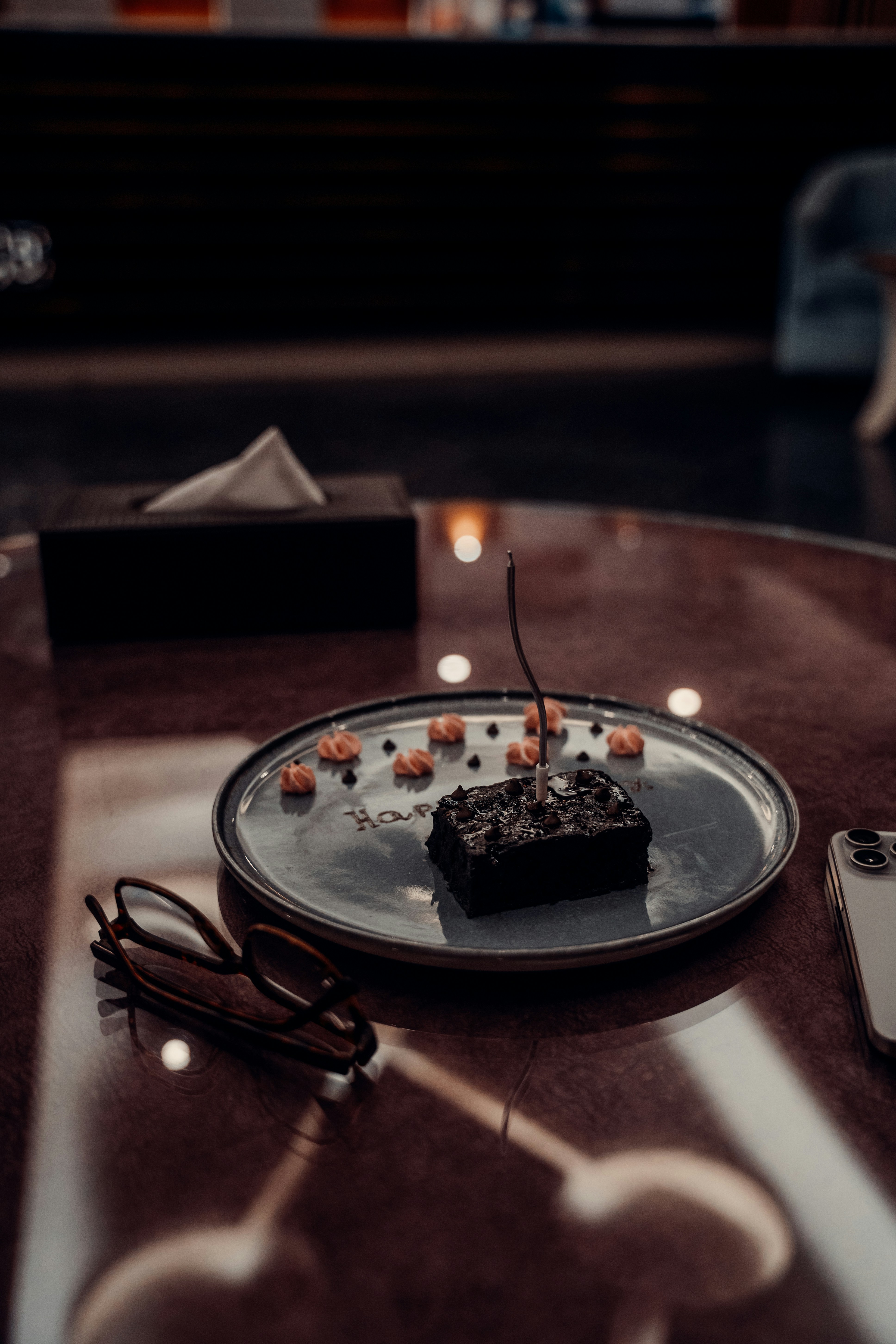 A single candle’s shadow: slice of chocolate at a quiet table