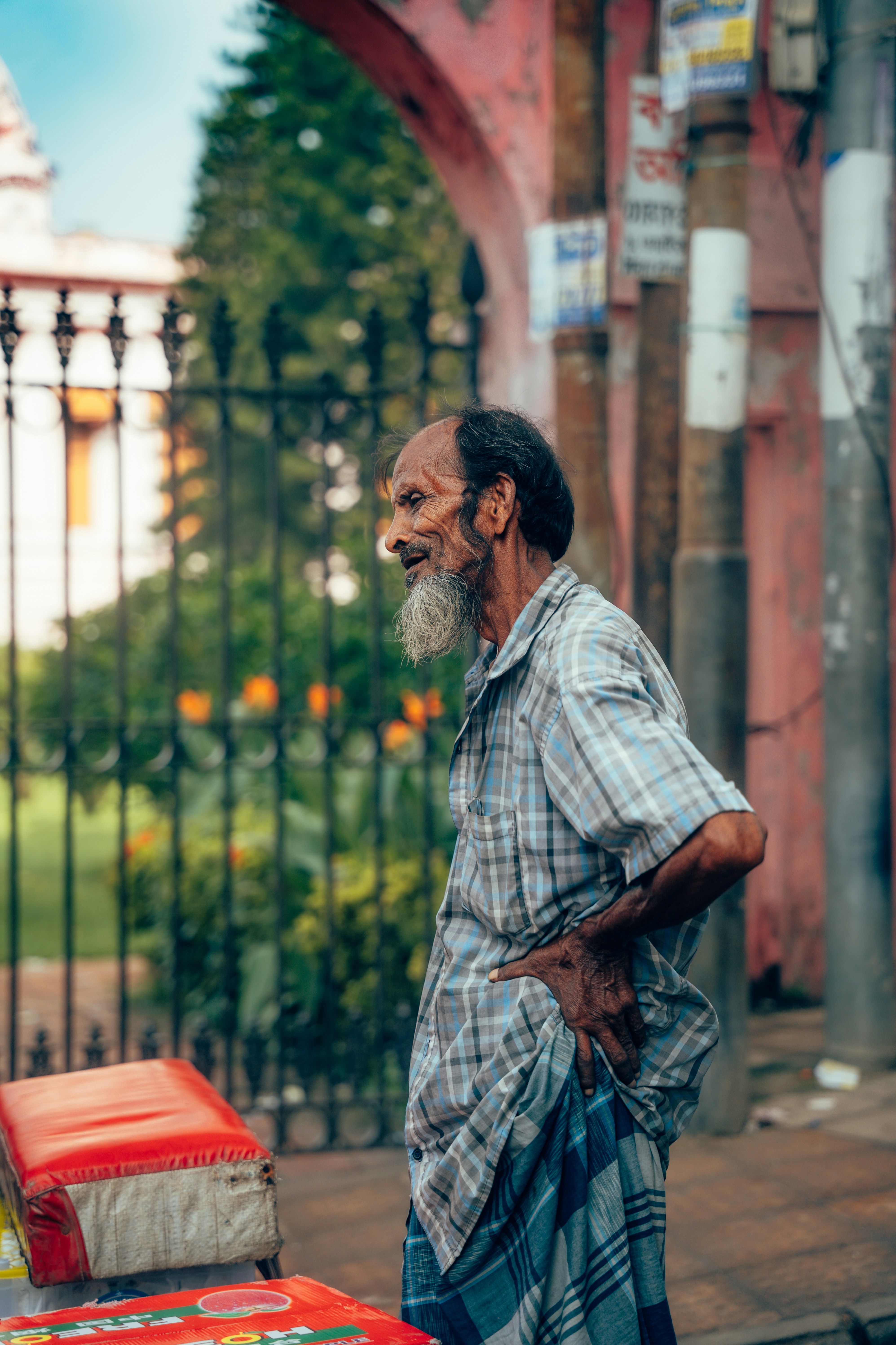 Sidelit Senior at a Sunlit Street Corner