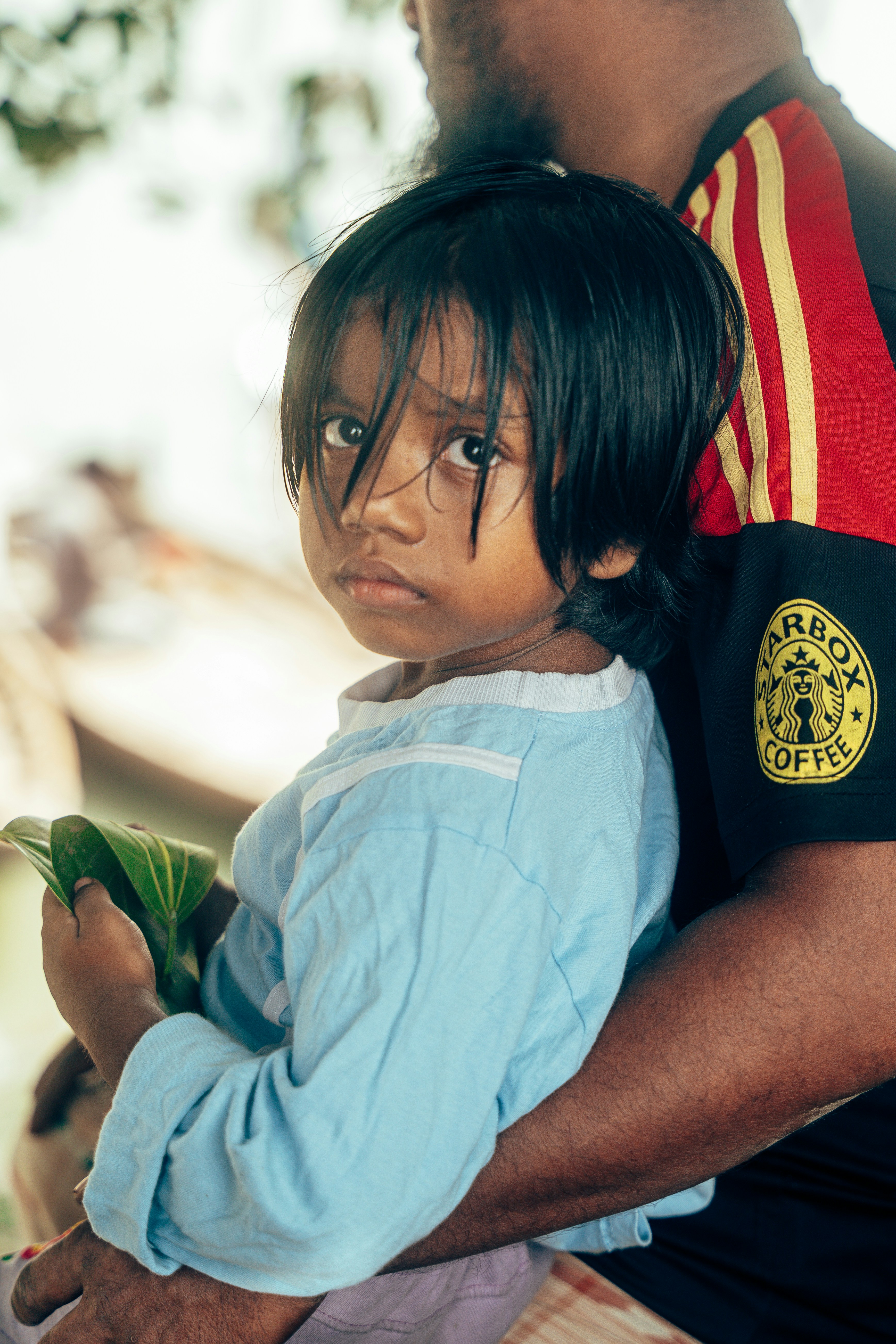 Eyes on the World: The Child’s Quiet Observant Moment in a Father’s Embrace