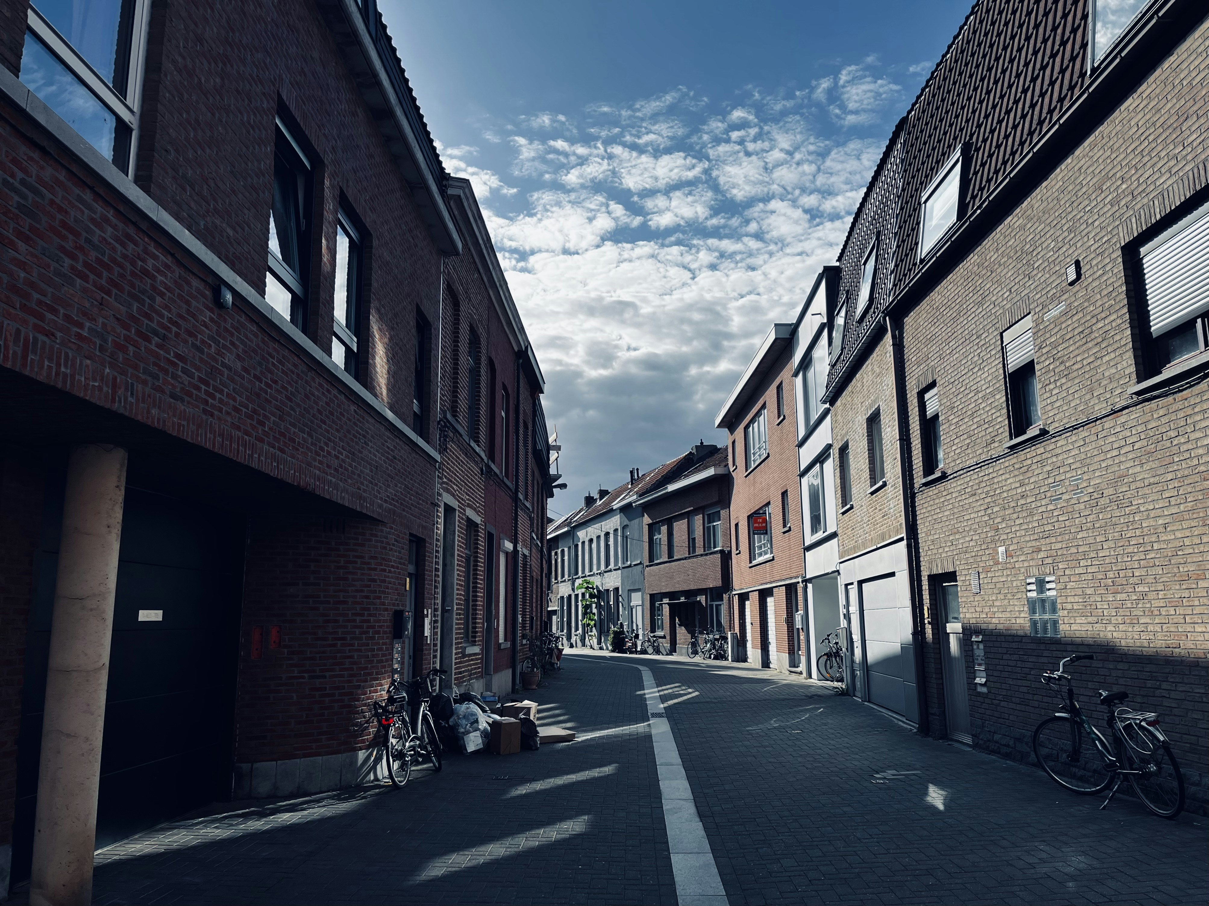 A Quiet European Street Opens to a Bright Sky