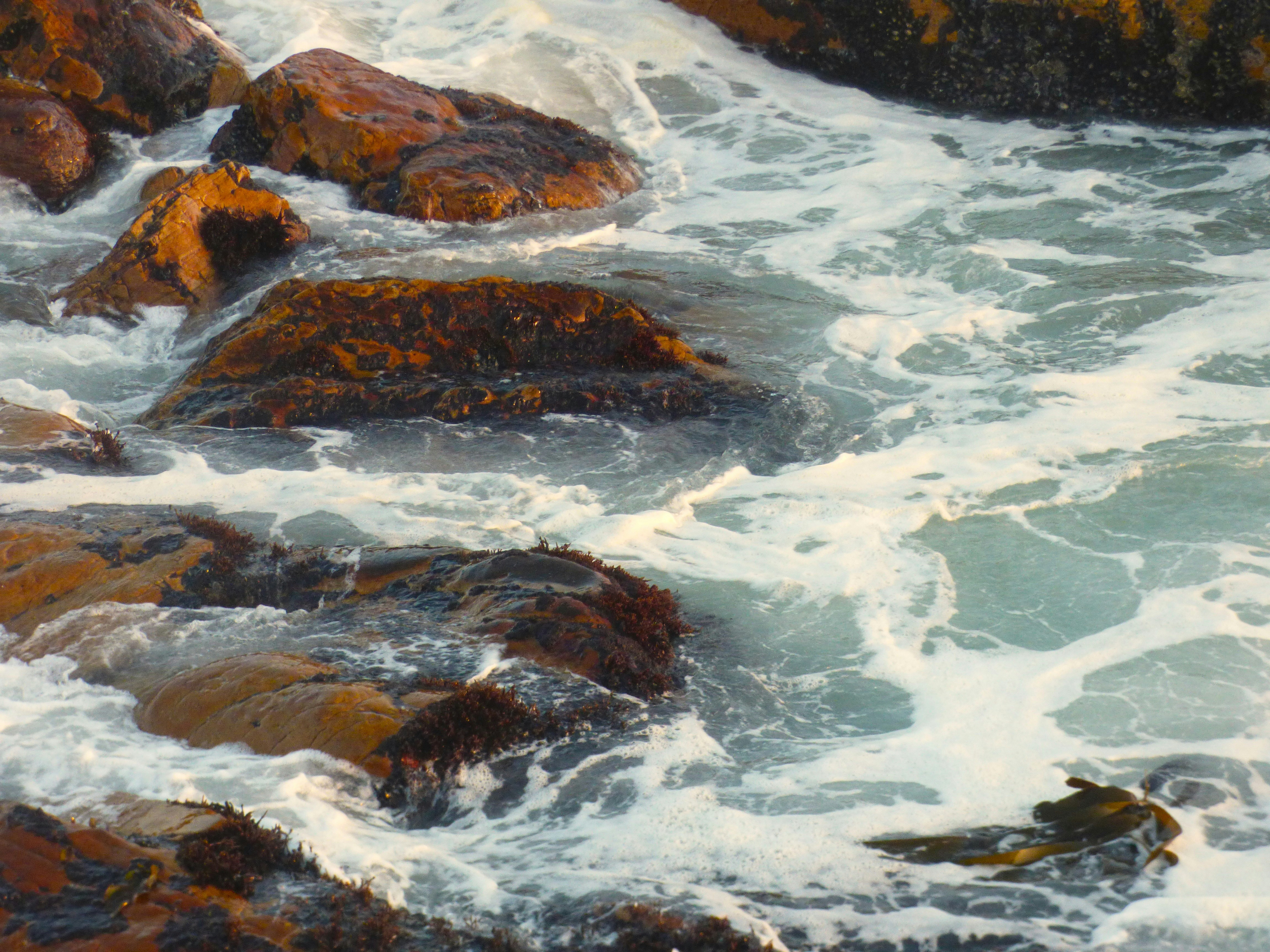 Foamy Crest over Weathered Rocks: A Seascape at Dusk