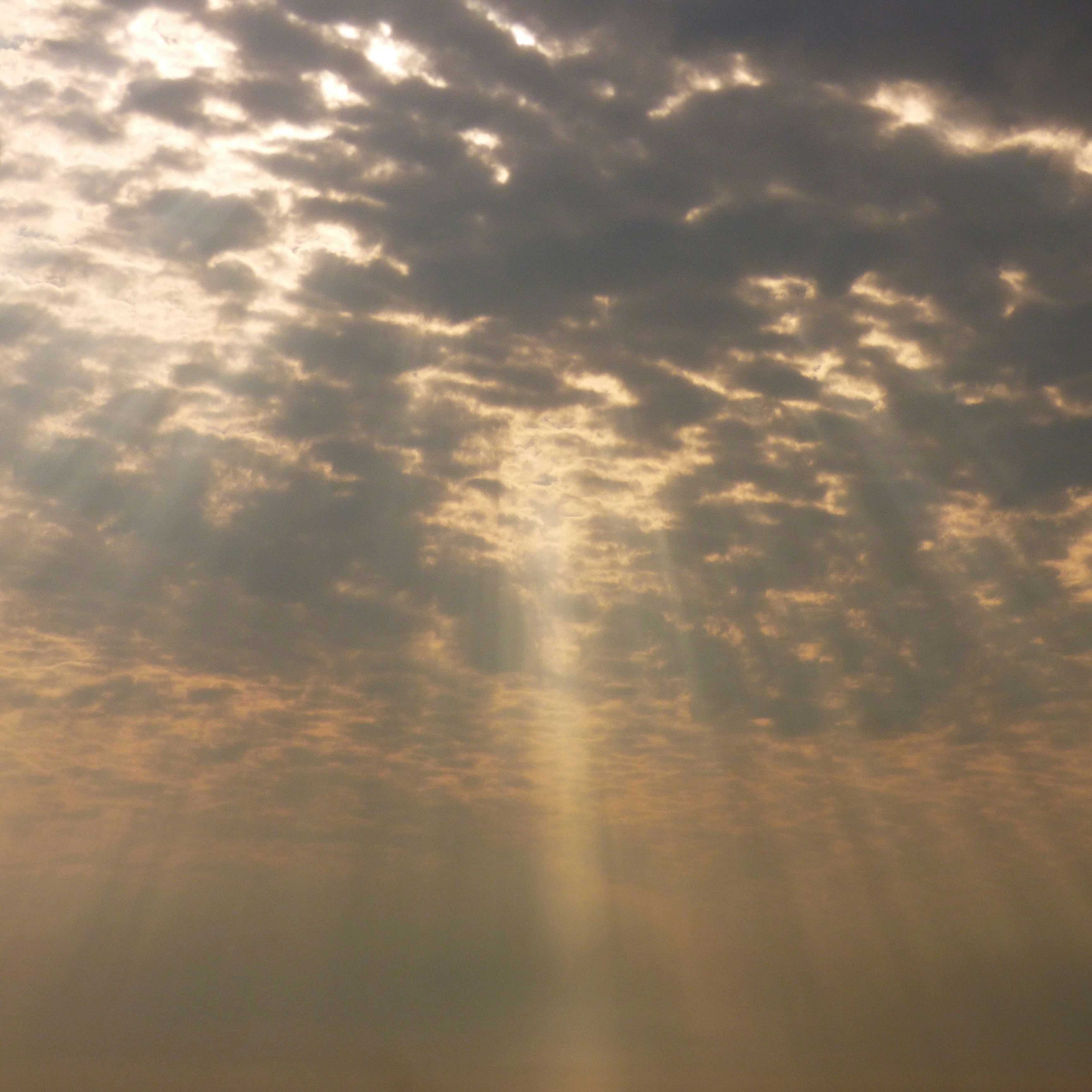 Sunbeams Piercing the Cloudbreak over a Quiet Horizon