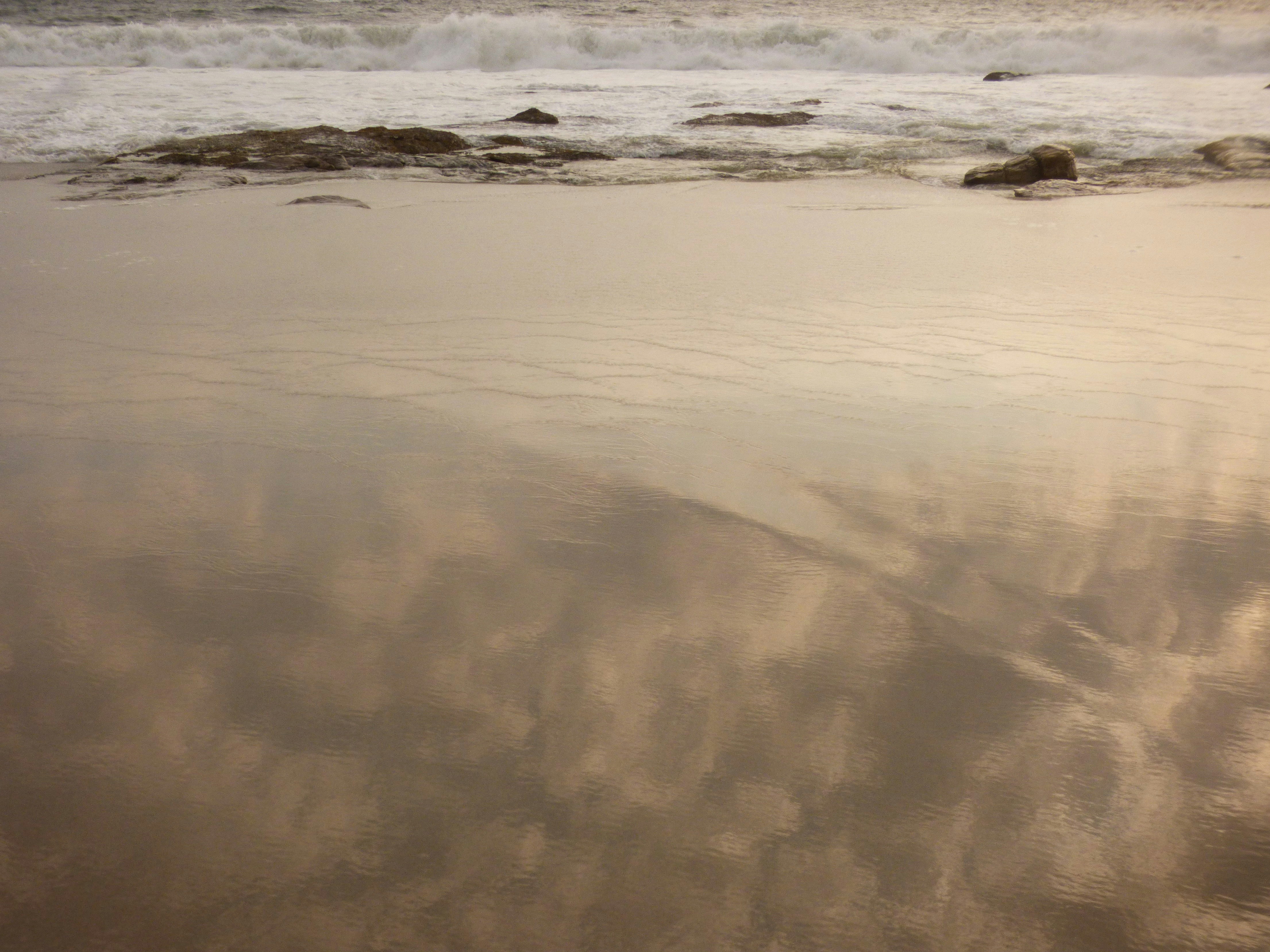 Soft Dawn on Wet Sand: Reflections and Gentle Waves
