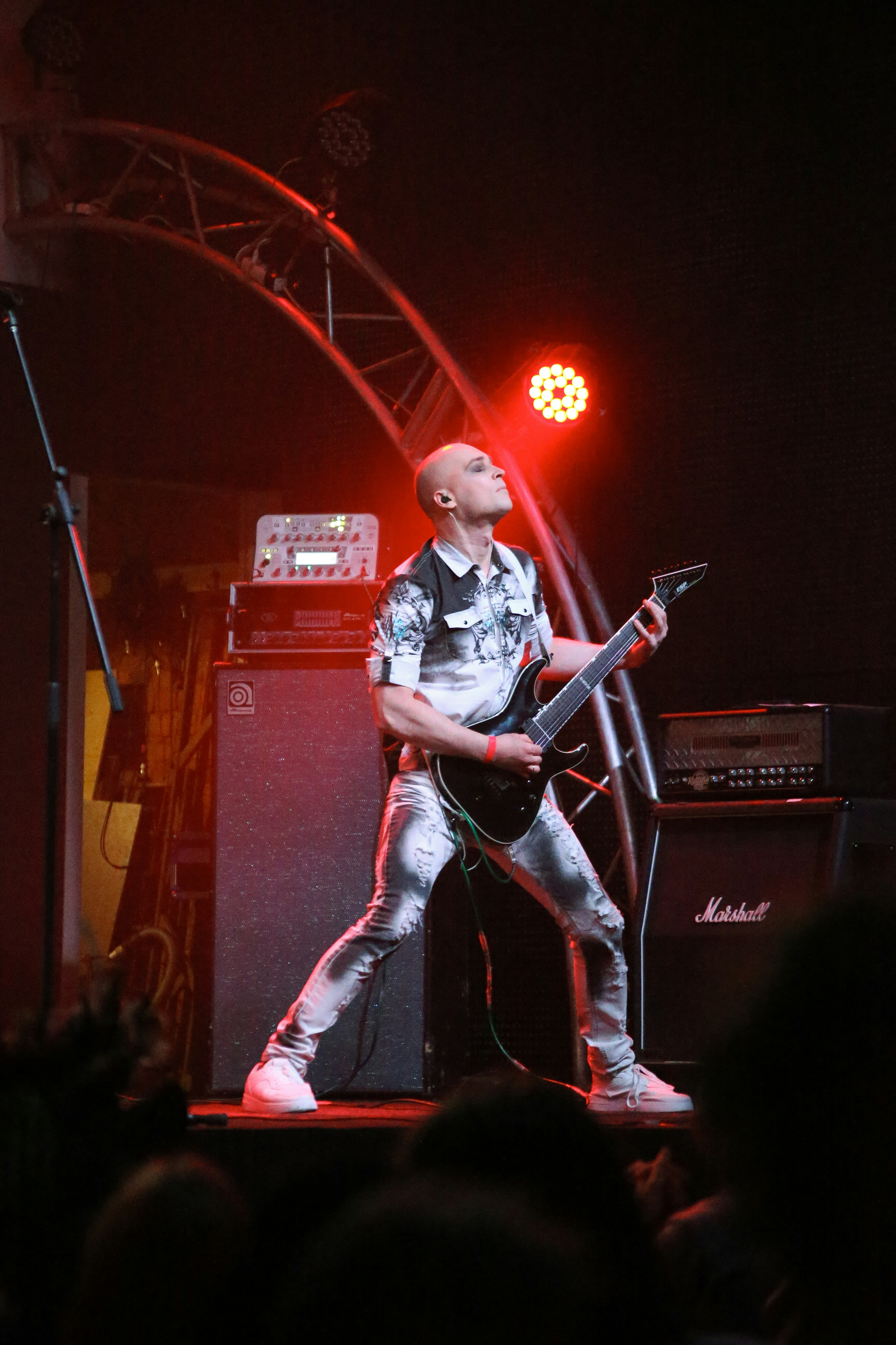 Guitarist in Red Stage Light Controls the Energy at Midnight Show