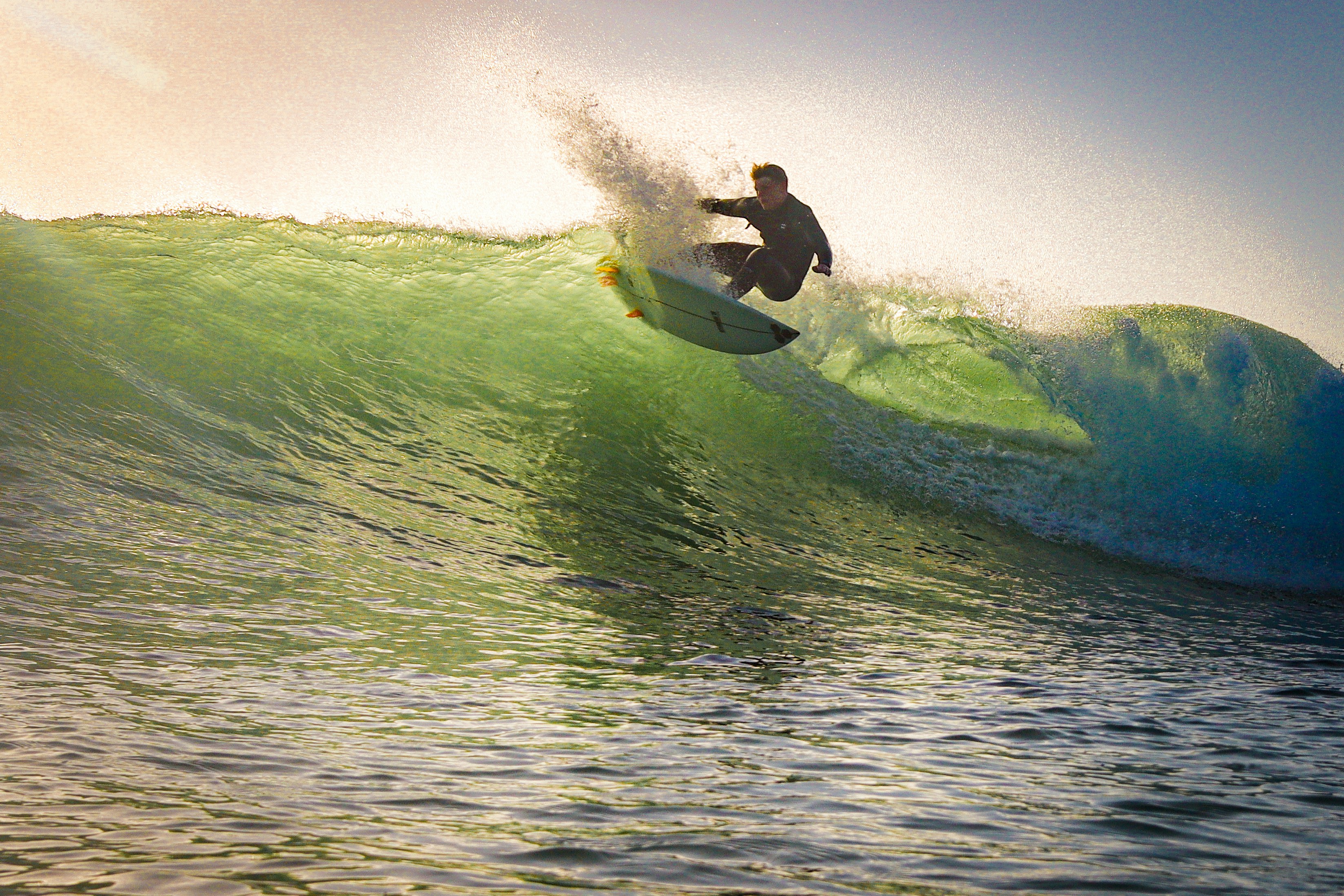 Alee-side Ride: surfer carving a emerald crest as the wave unfurls