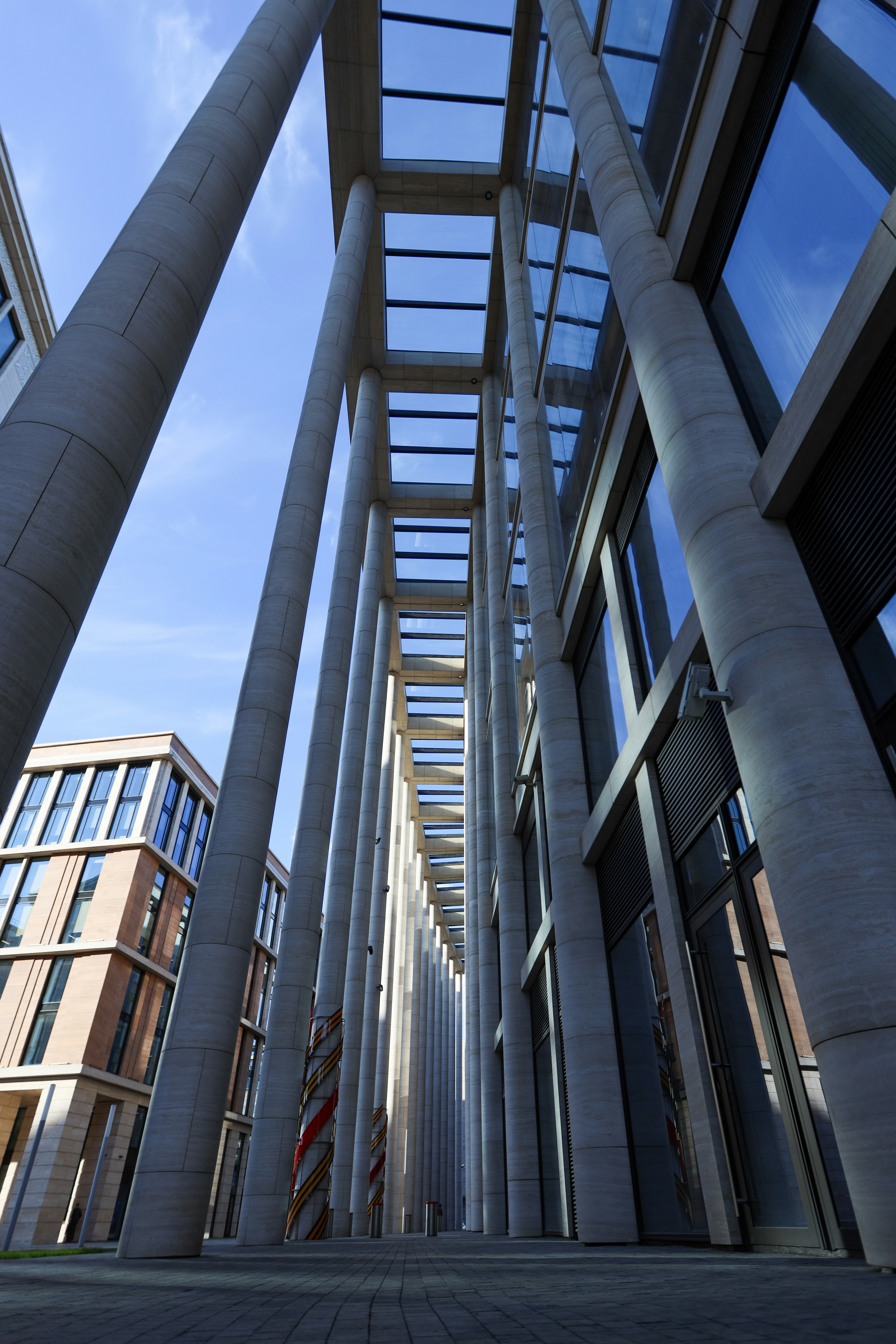 Columns of Perspective: A Corridor of Vertical Lines Under Glass Sky