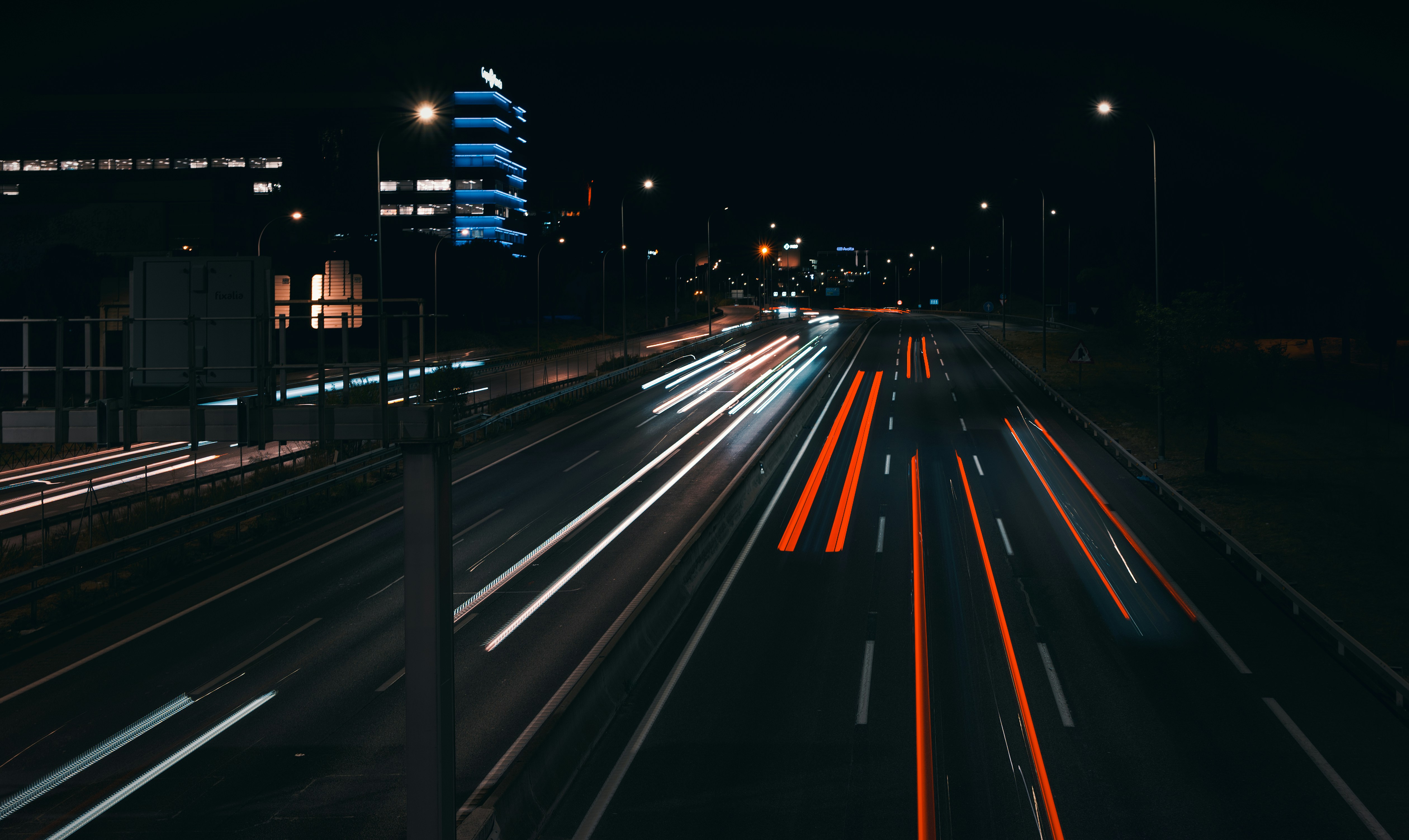 Midnight Highway: Long-Exposure Flow of Neon-Tailed Traffic