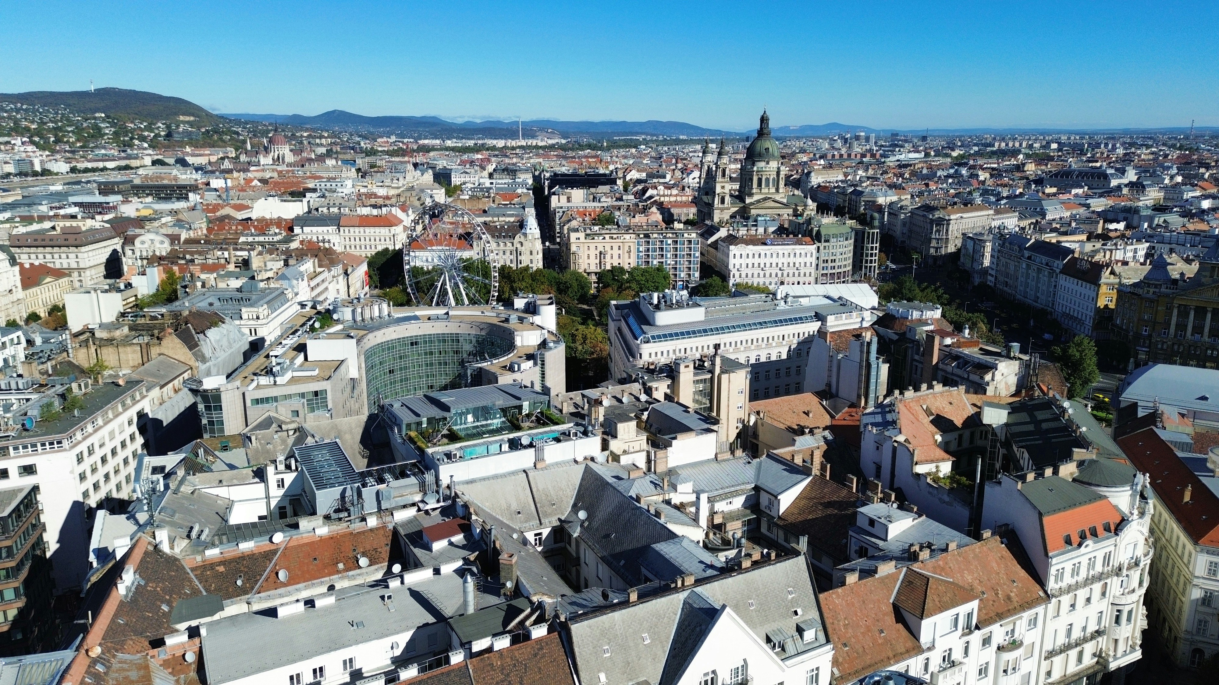 Aerial Tapestry: Prague’s Rooftops Unfold Beneath a Wide Blue Sky