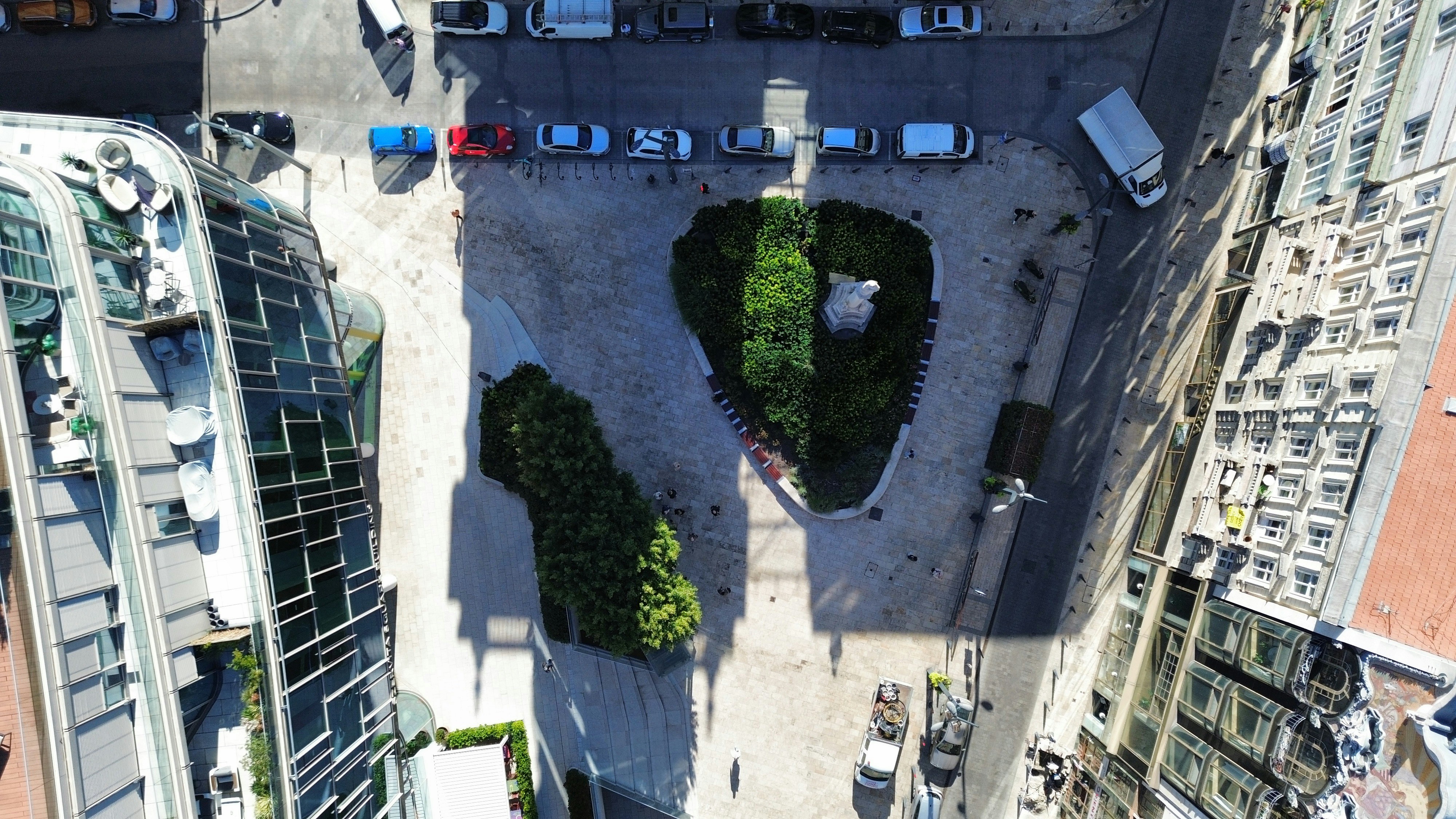Aerial Rhythm: City Square with Sunlit Arch and Shaded Path