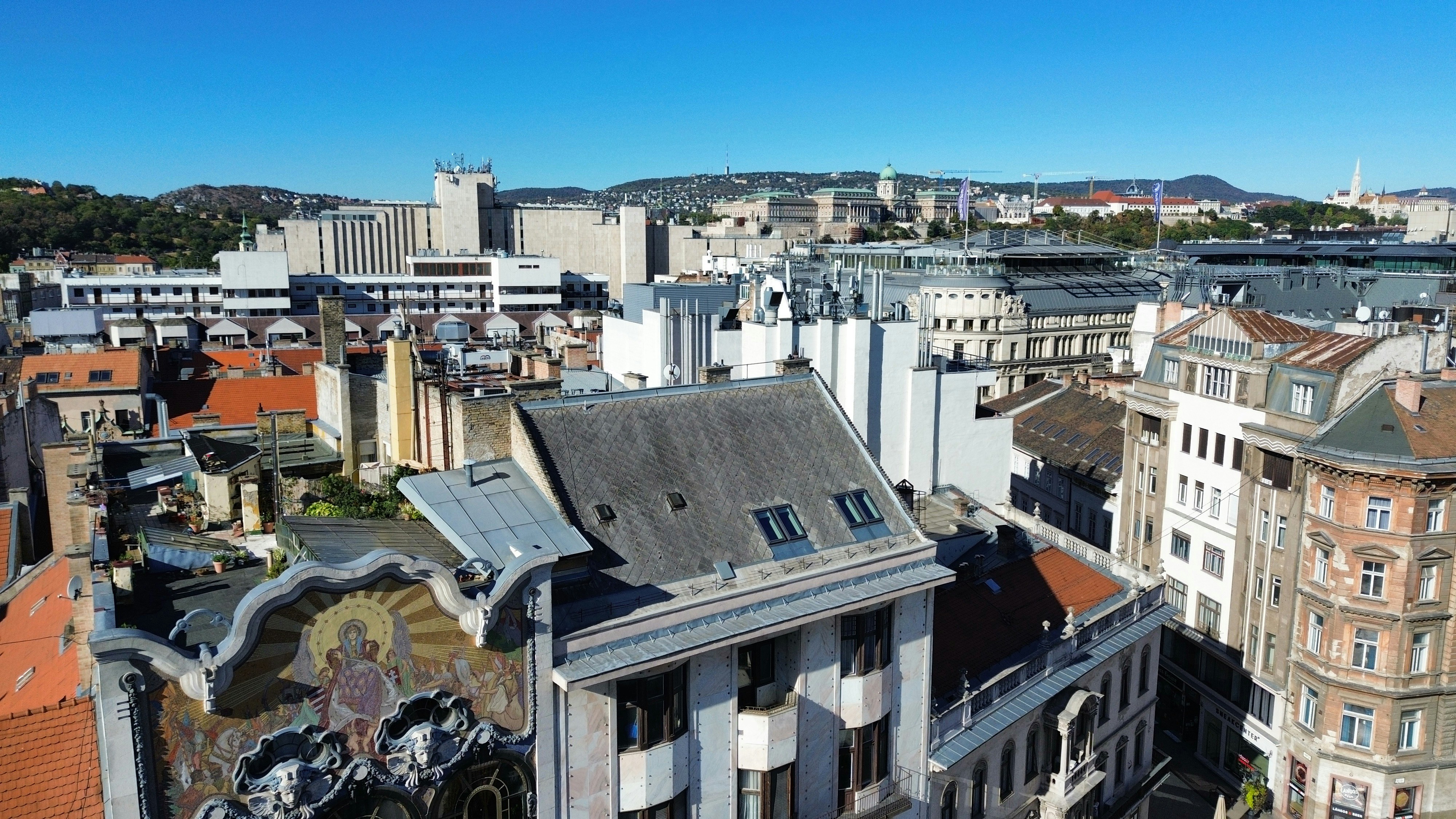 Rooftop Mosaic Amid a Cityrise: Windows, Tiles, and Spire