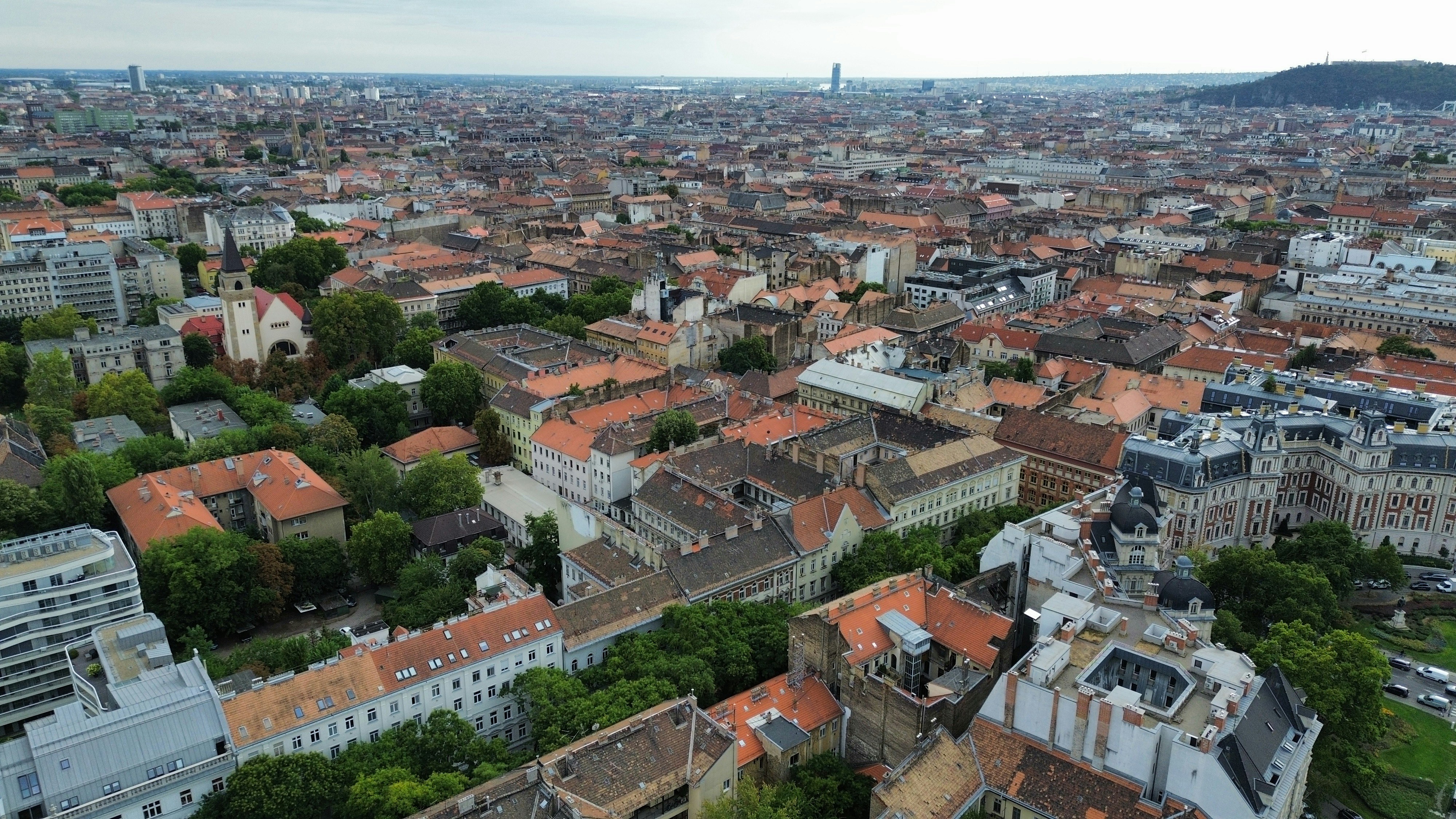 Cityscape Mosaic: Red-Tiled Roofs and Green Courtyards from Above