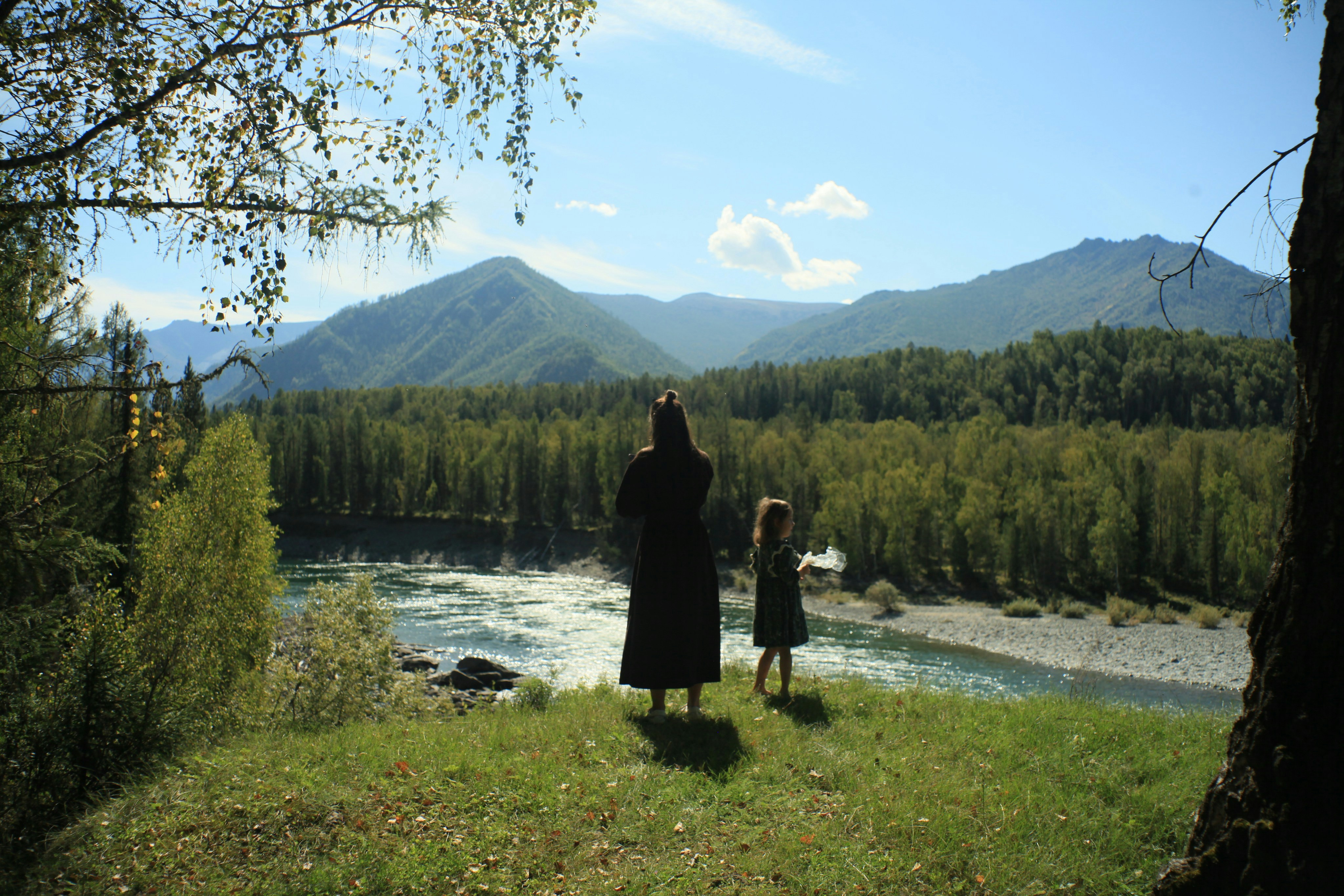 Two Silhouettes by the River Amid Mountain Pines