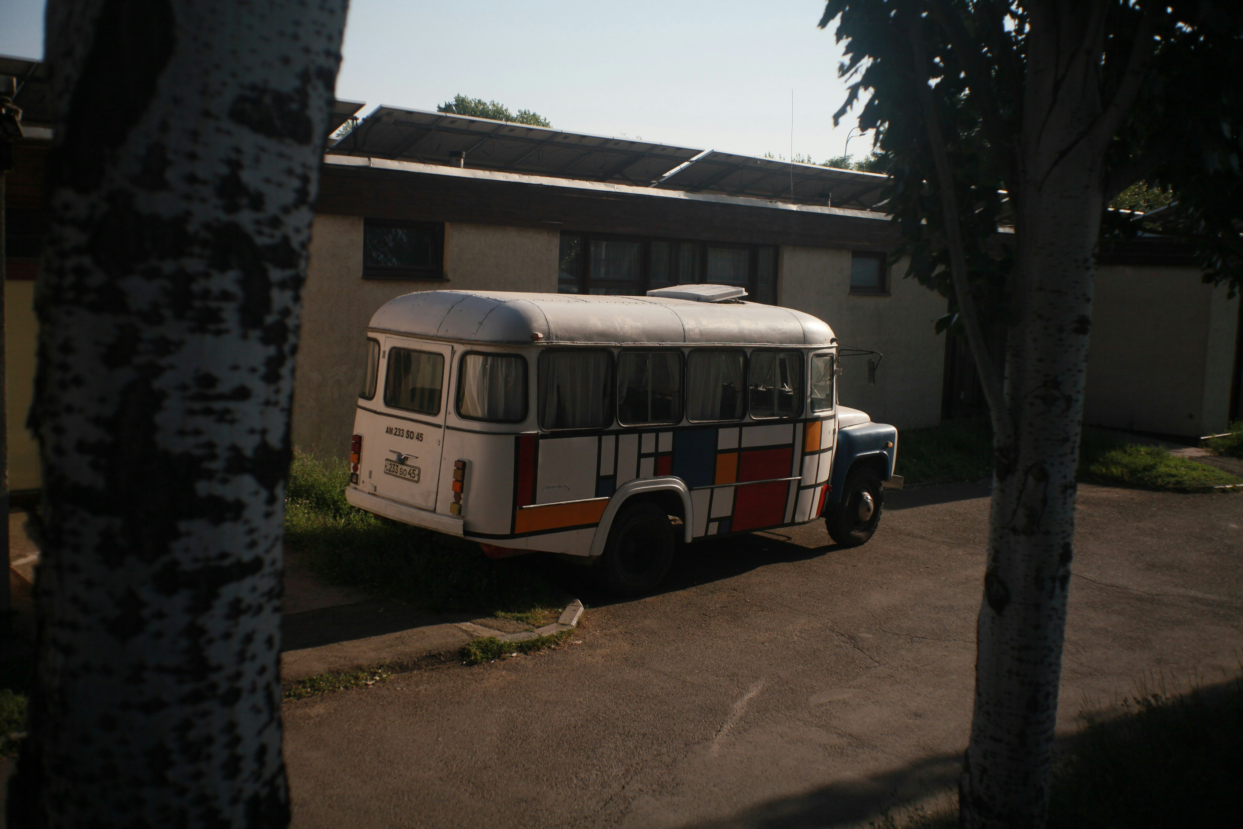 Old Bus in a Quiet Courtyard: Shadowed Light and Quiet Decay