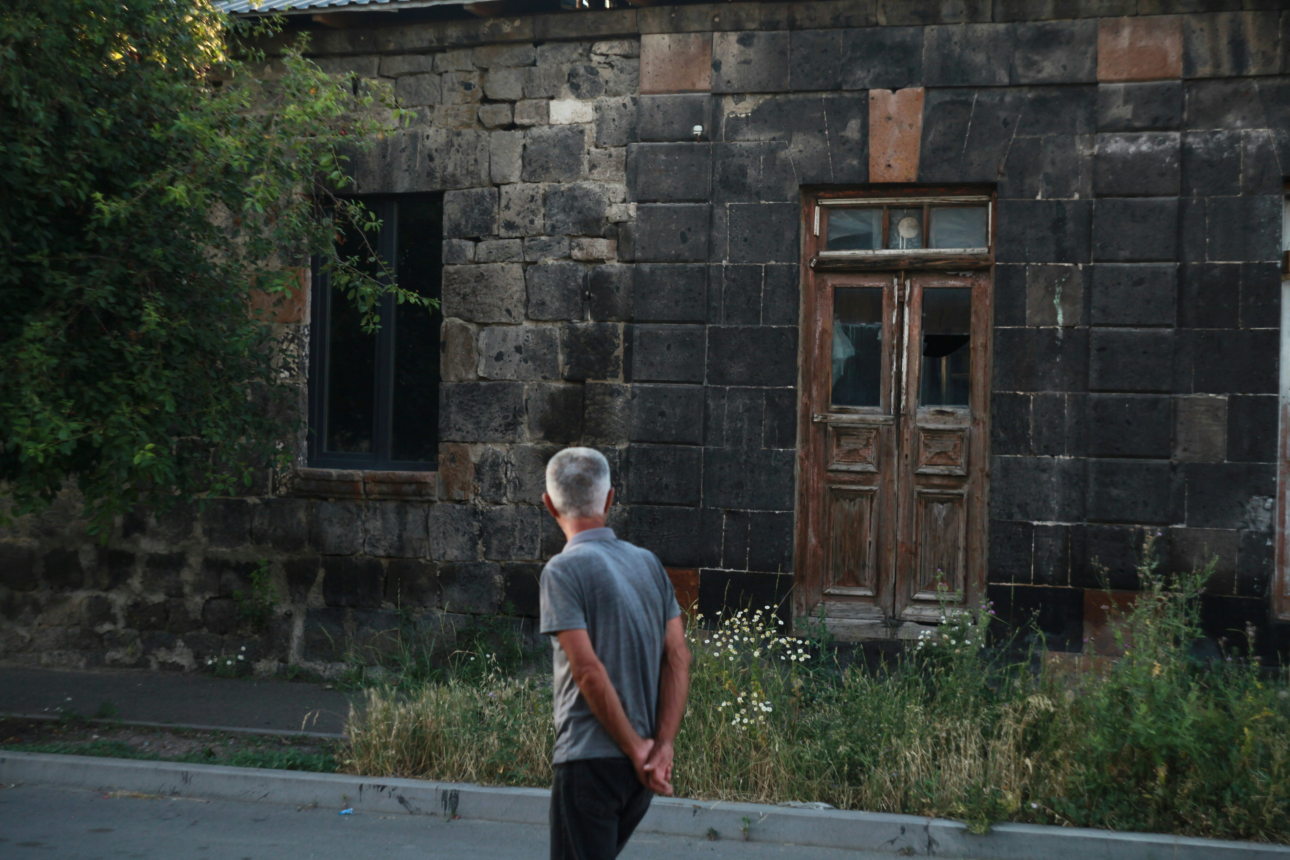 Stray Figure Before a Weathered Doorway