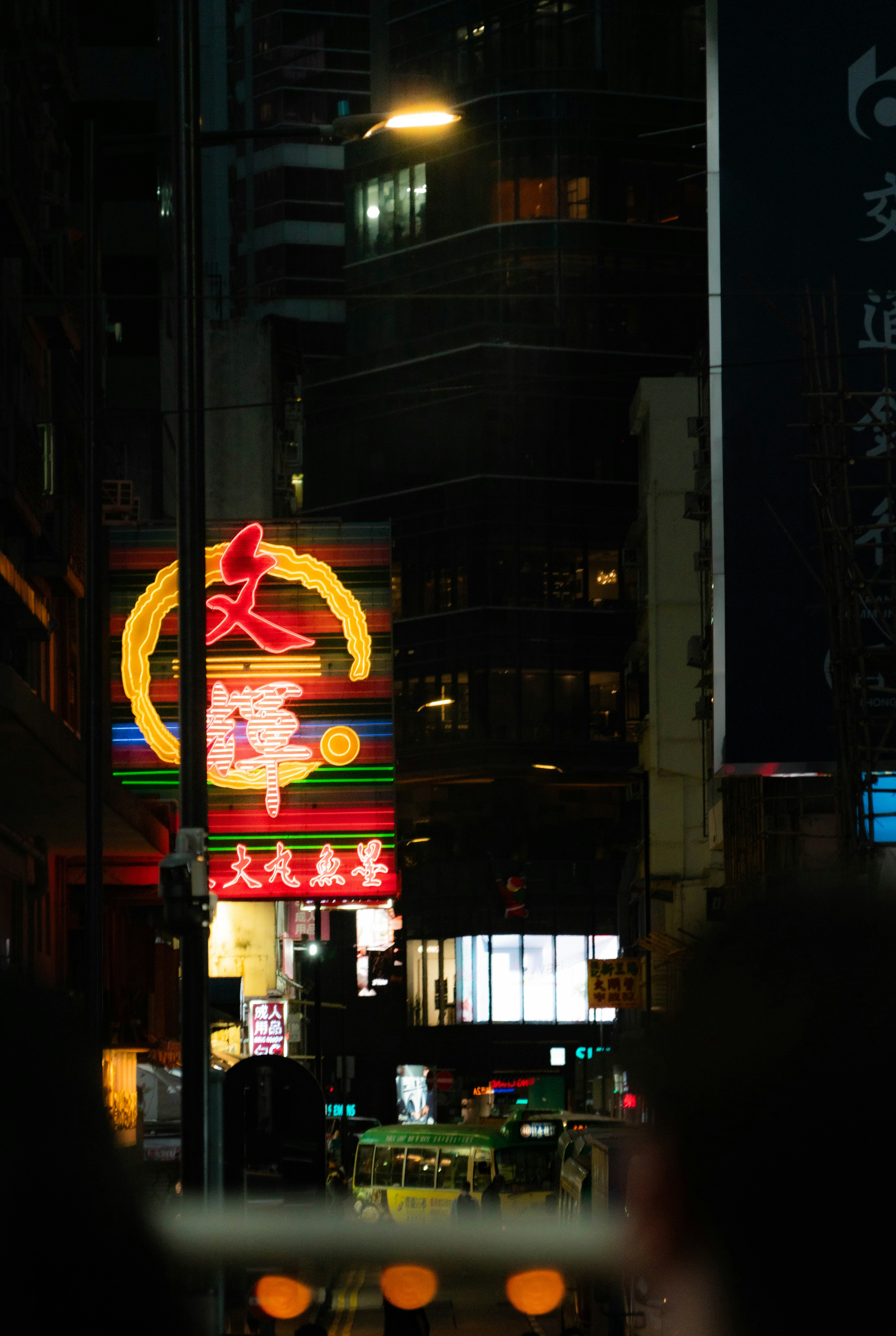 Neon Signage Piercing the Night in a Bustling Urban Alley