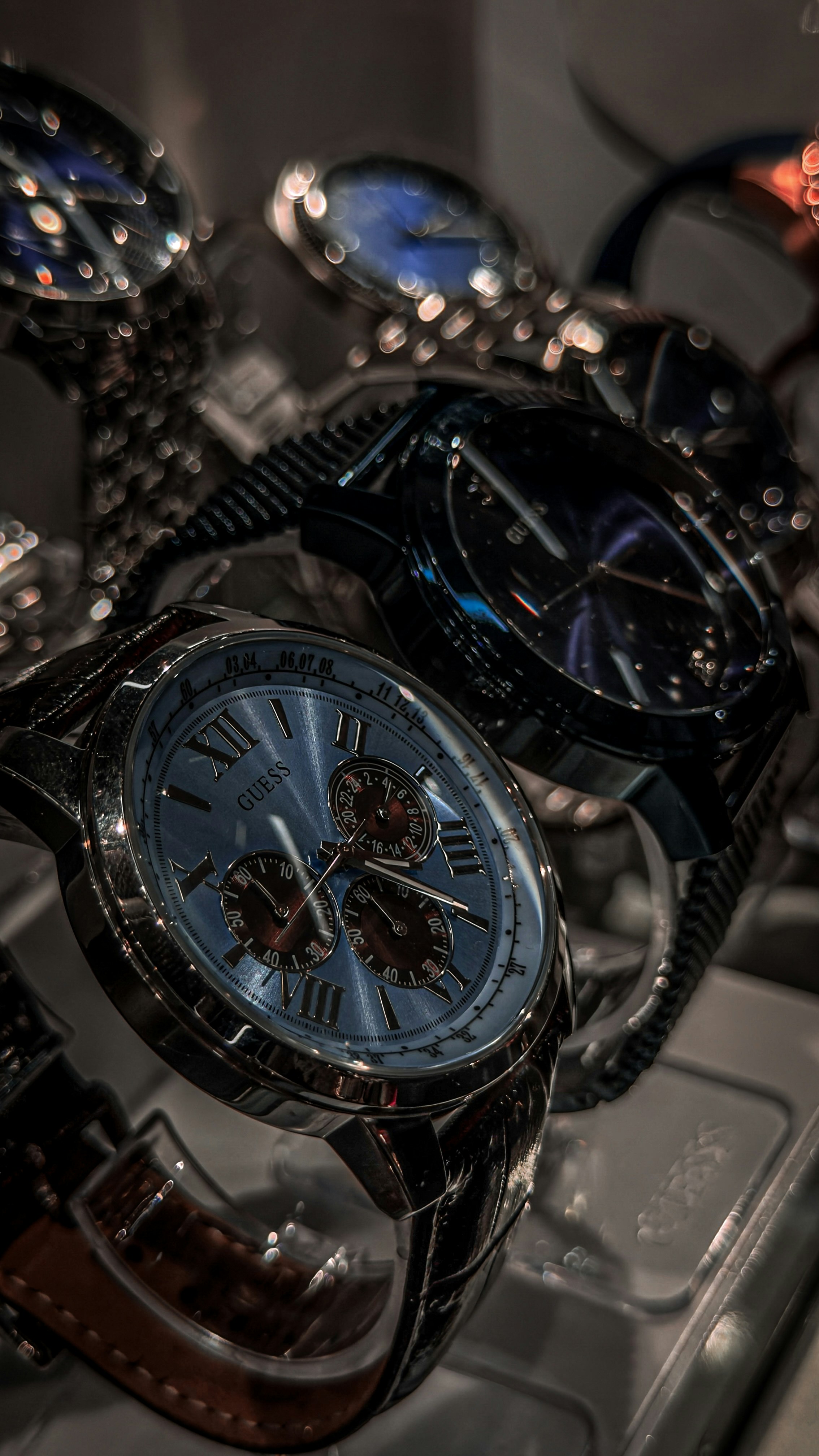 Guessed Time: A close-up of a chronograph collection's face gleaming under showroom light