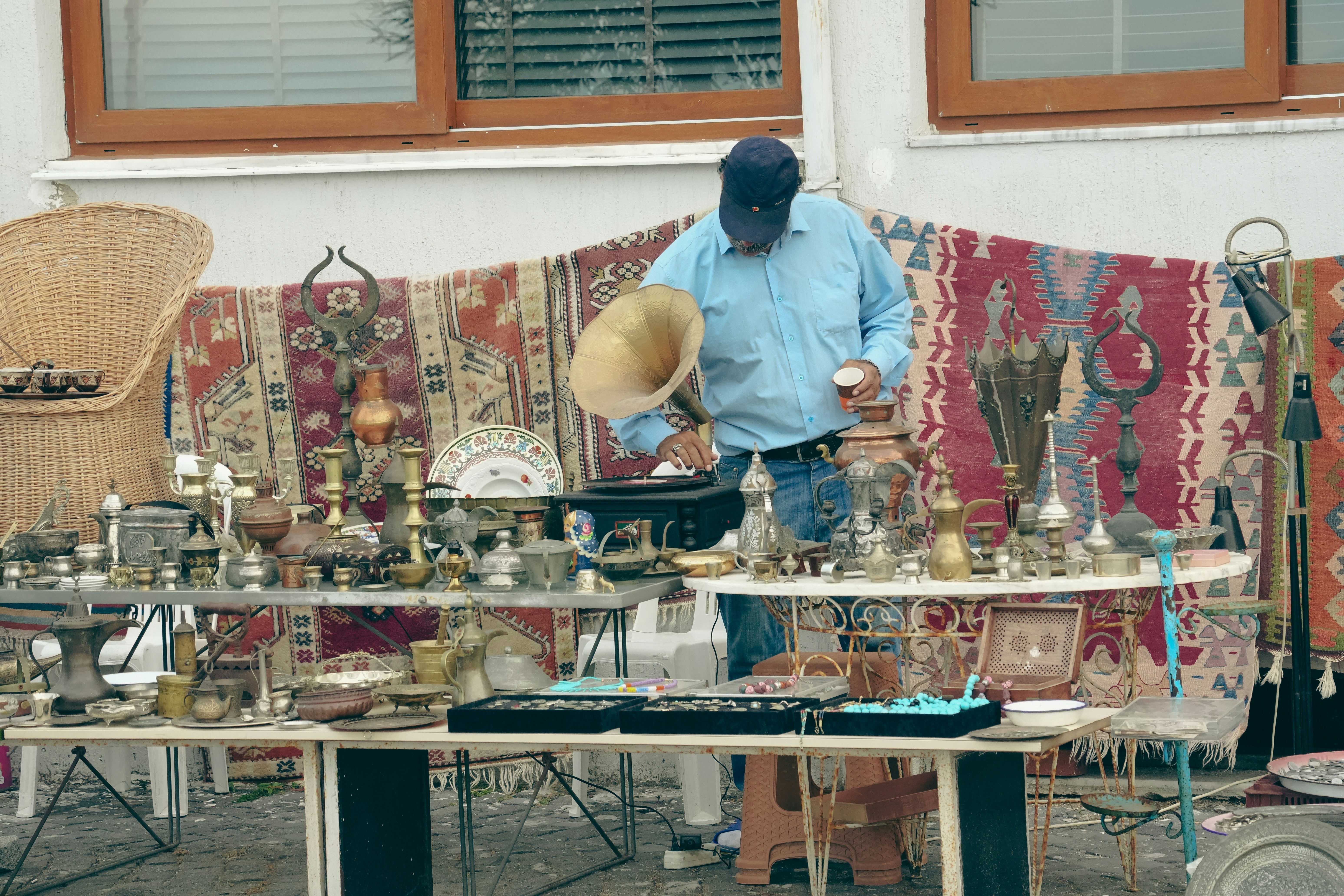 Dealer of antique echoes: a man dusting history at a street-side bazaar