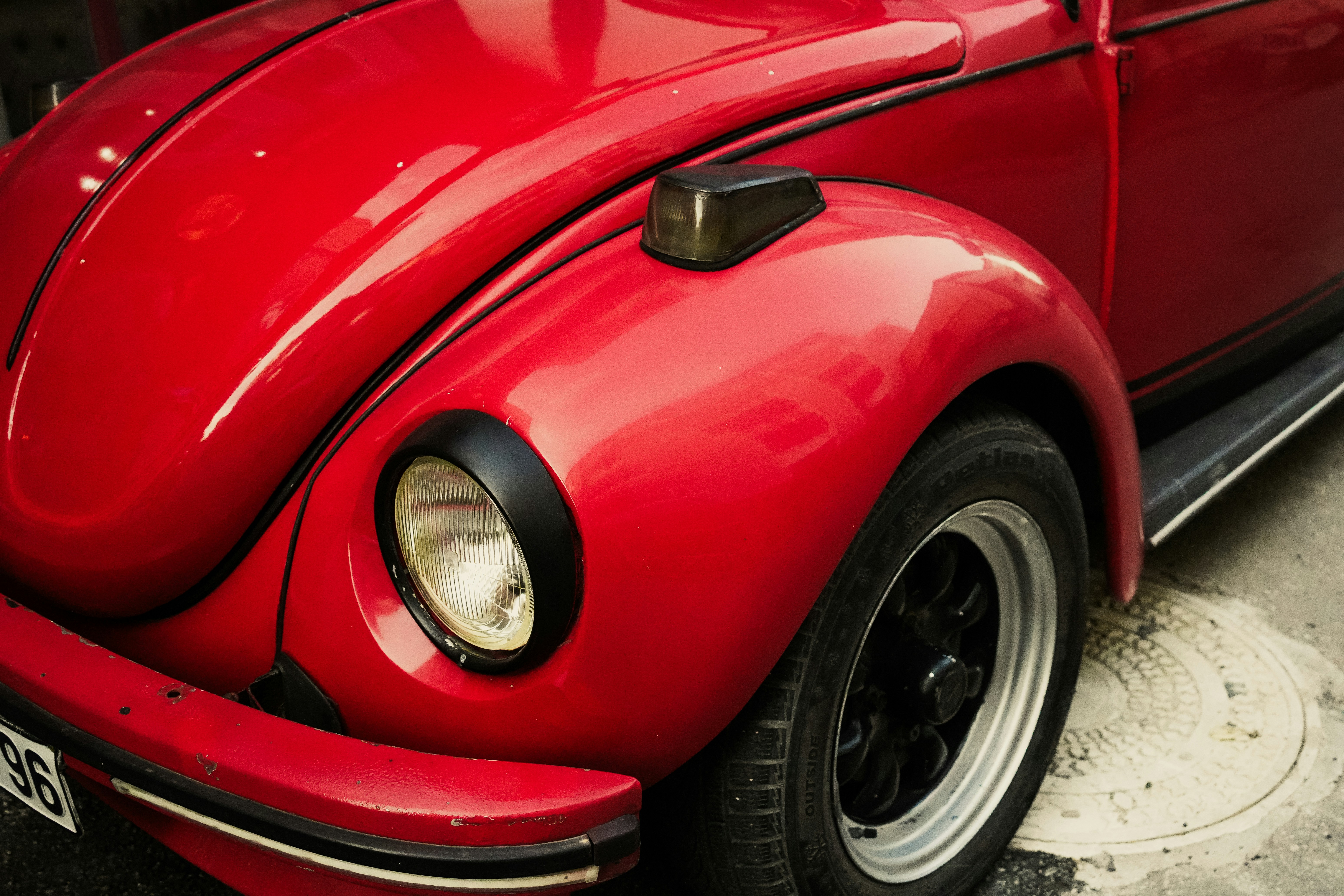 Curved Red Chrome: A Retro Volkswagen Beetle's Front Quarter