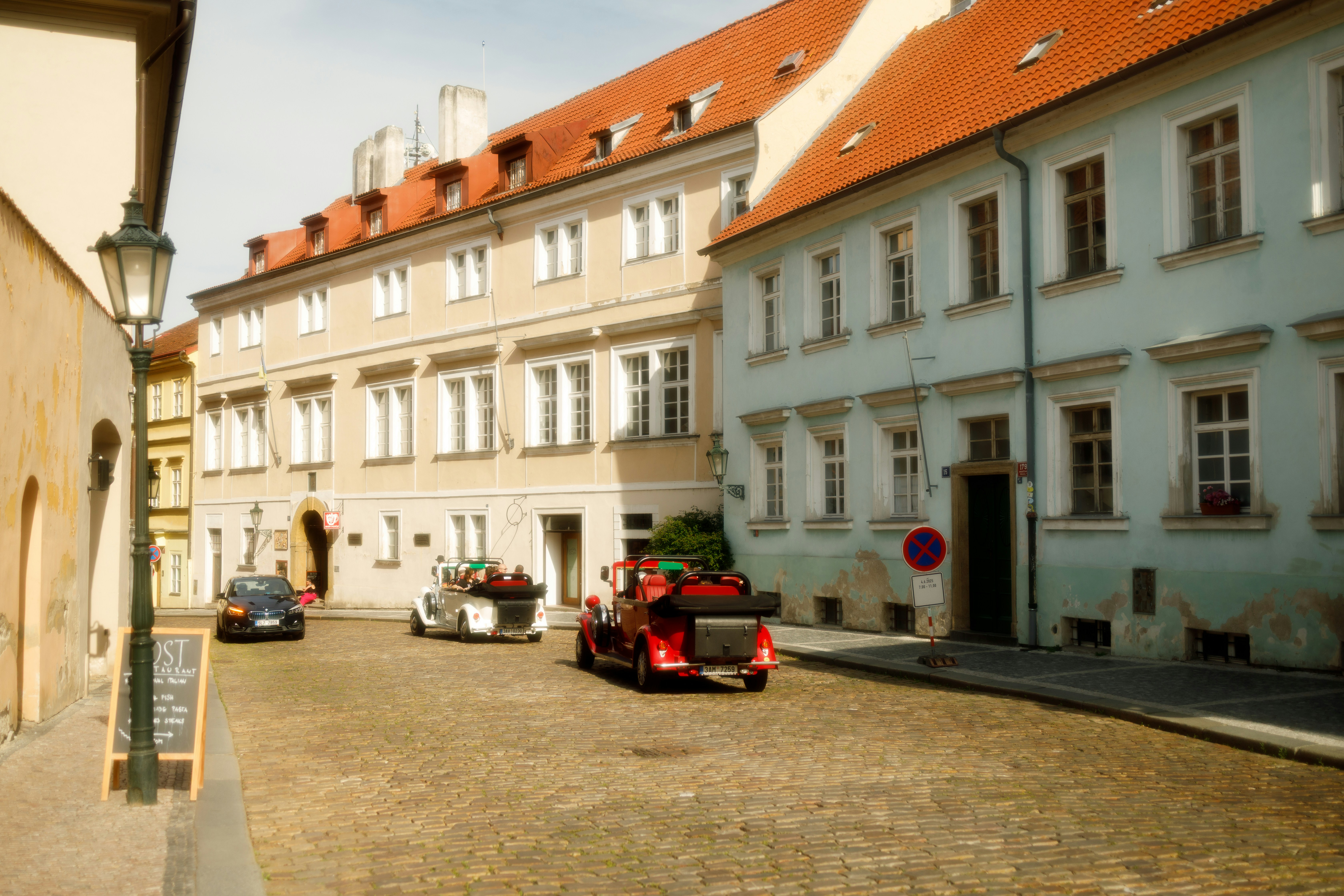 Sunlit Cobblestones and Classic Cars on a Quiet European Street