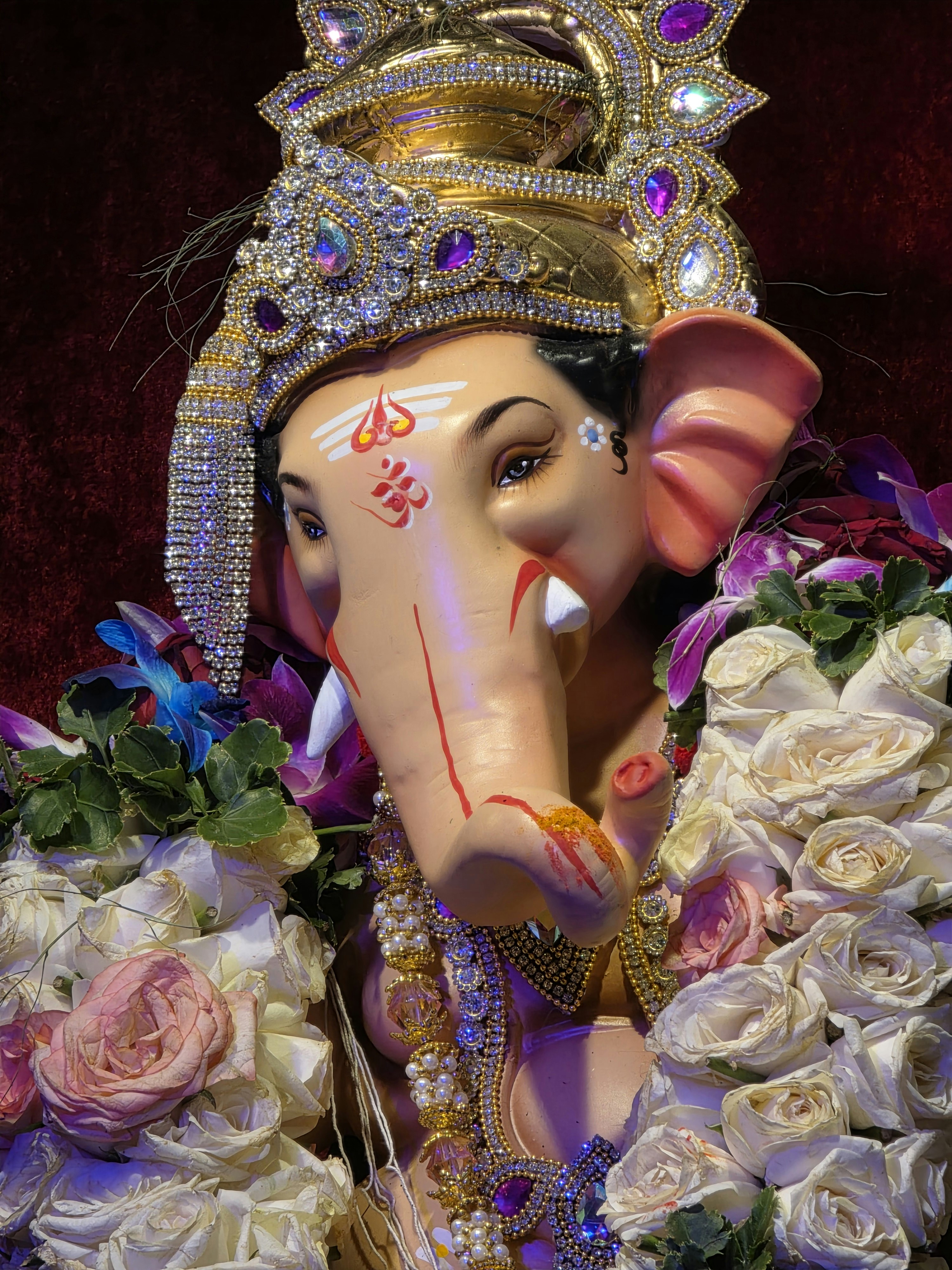 Regal Ganesh: The Floral Crowned Idol Surrounded by Blooming Ambiance