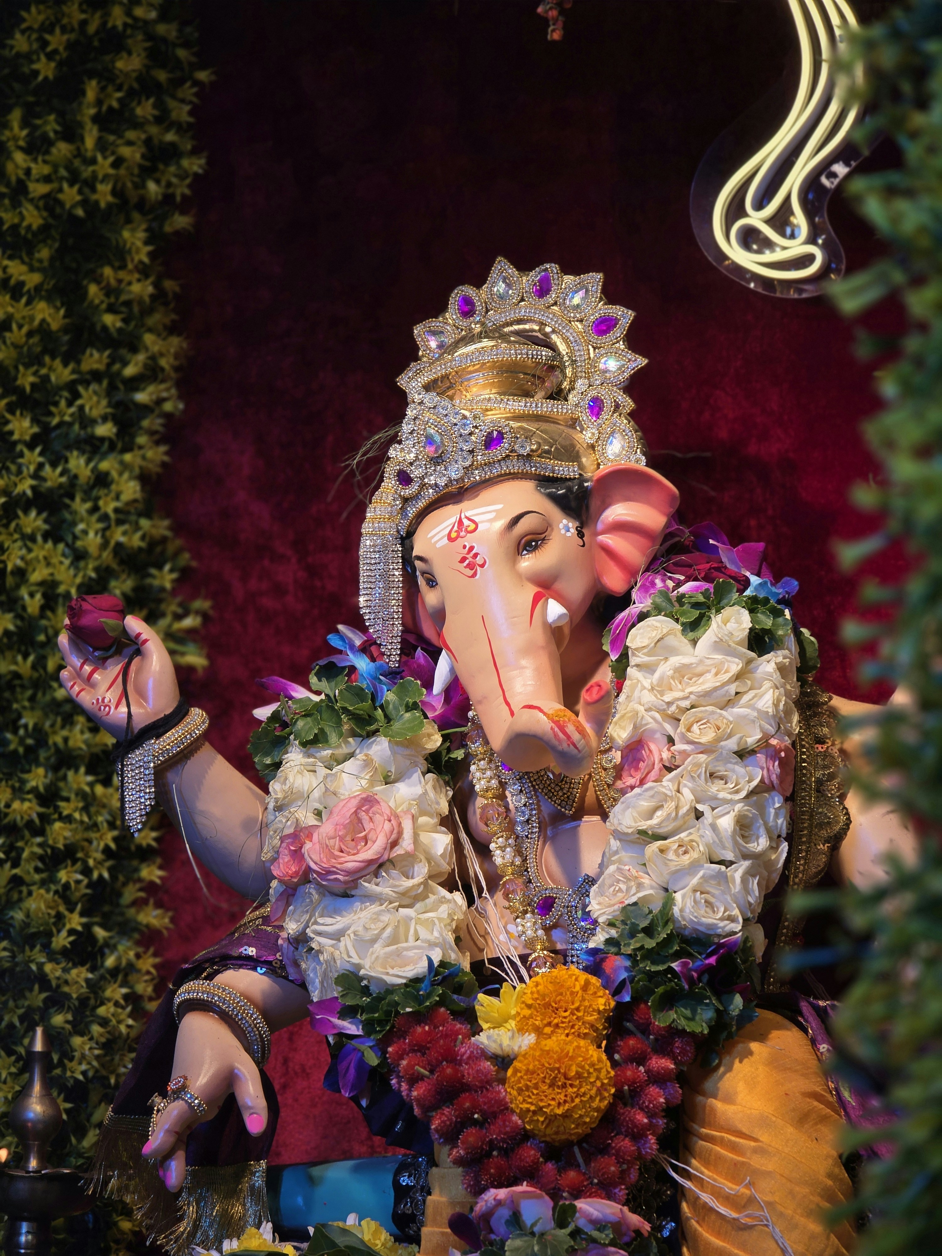 Ornate Ganesh Idol Emerges Amid Floral Drapery and Velvet Backdrop