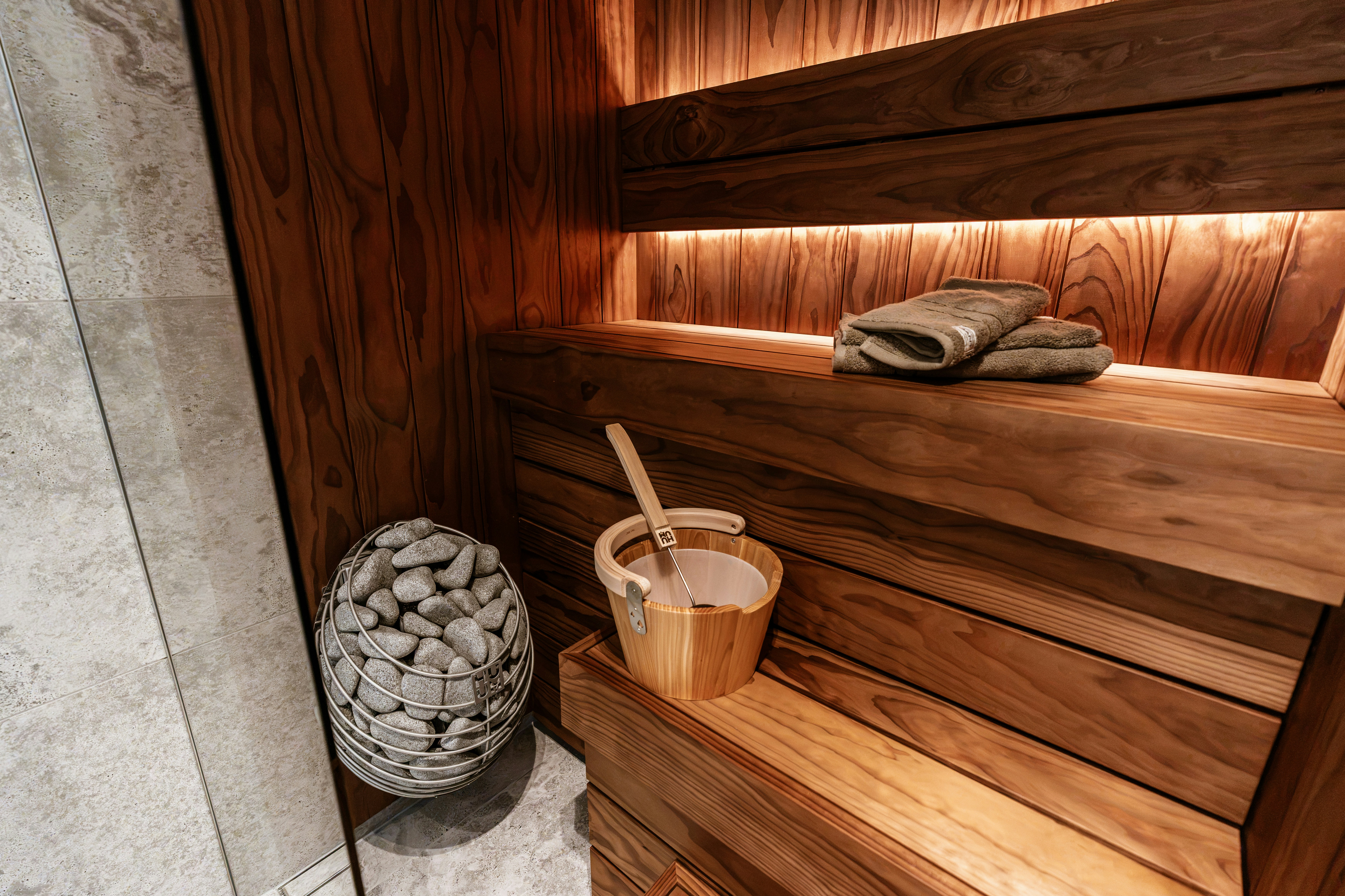 Warm Wooden Quiet: Sauna Benches and Sauna Bucket in Dim Light