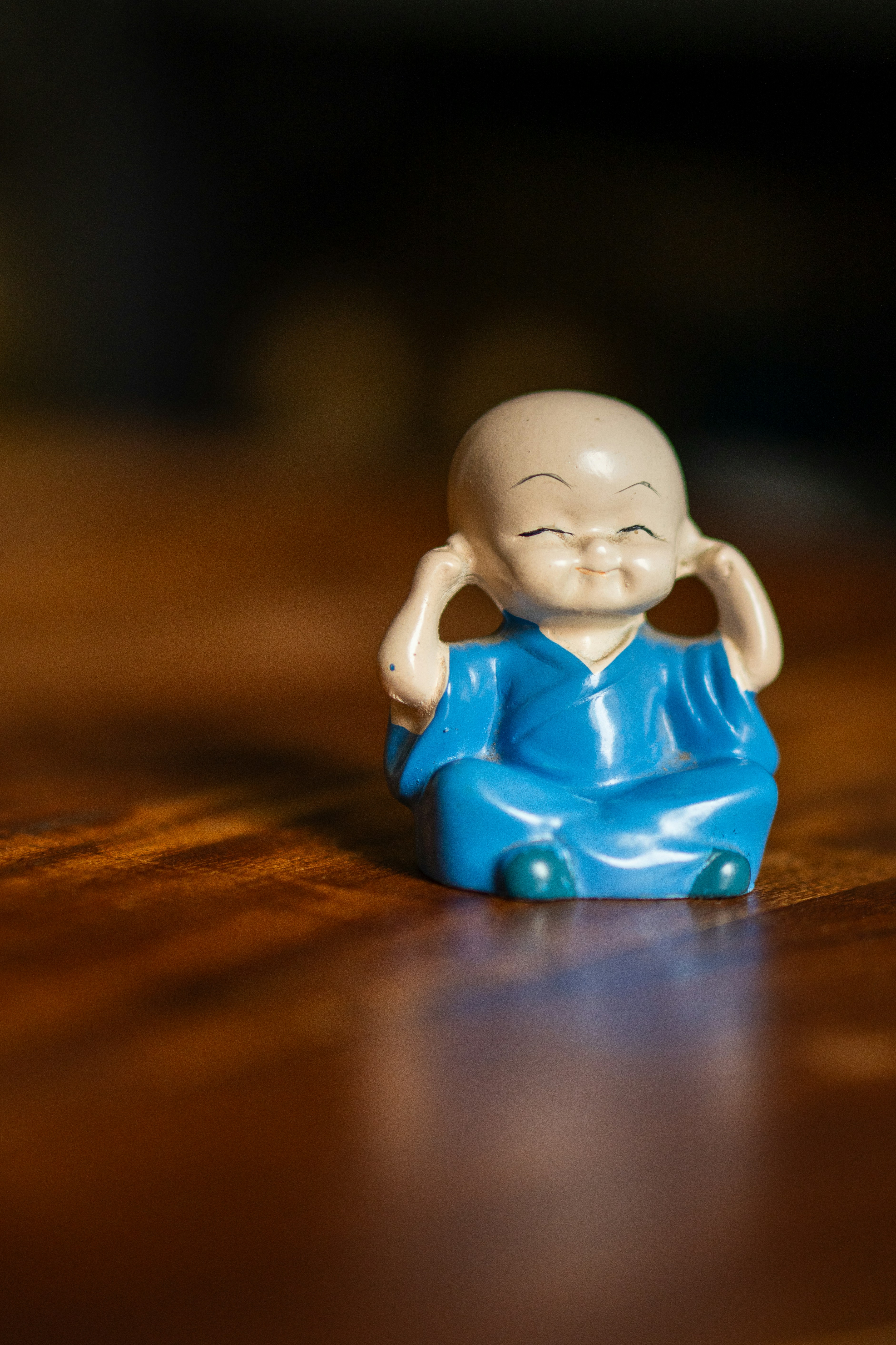 Tiny Zen: a smiling figurine in warm wood-toned light