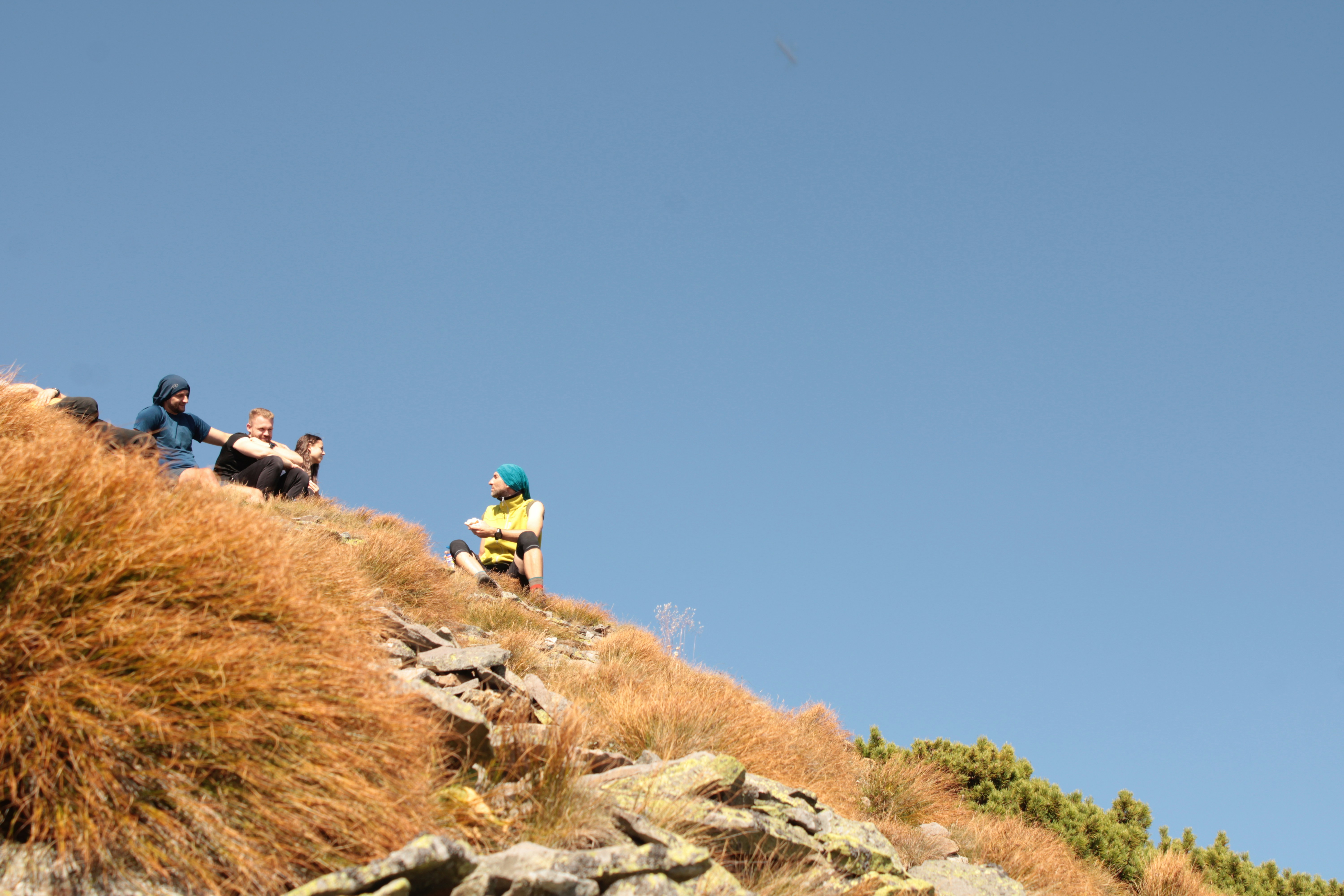 Cliffside Summit: hikers pause along the ridge under a clear sky
