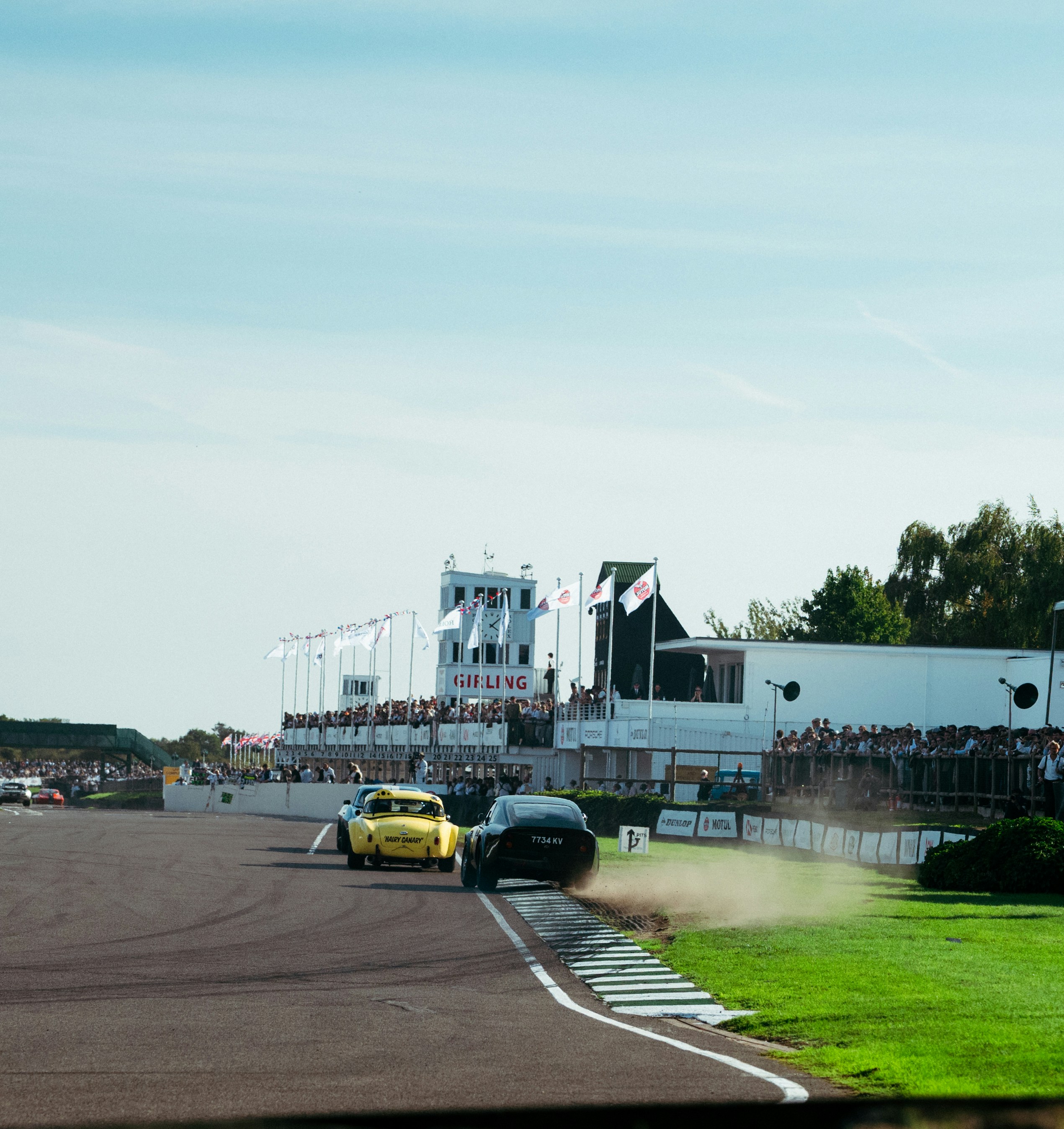 Yellow Car, Black Car, and a Dusty Drift on a Race Day
