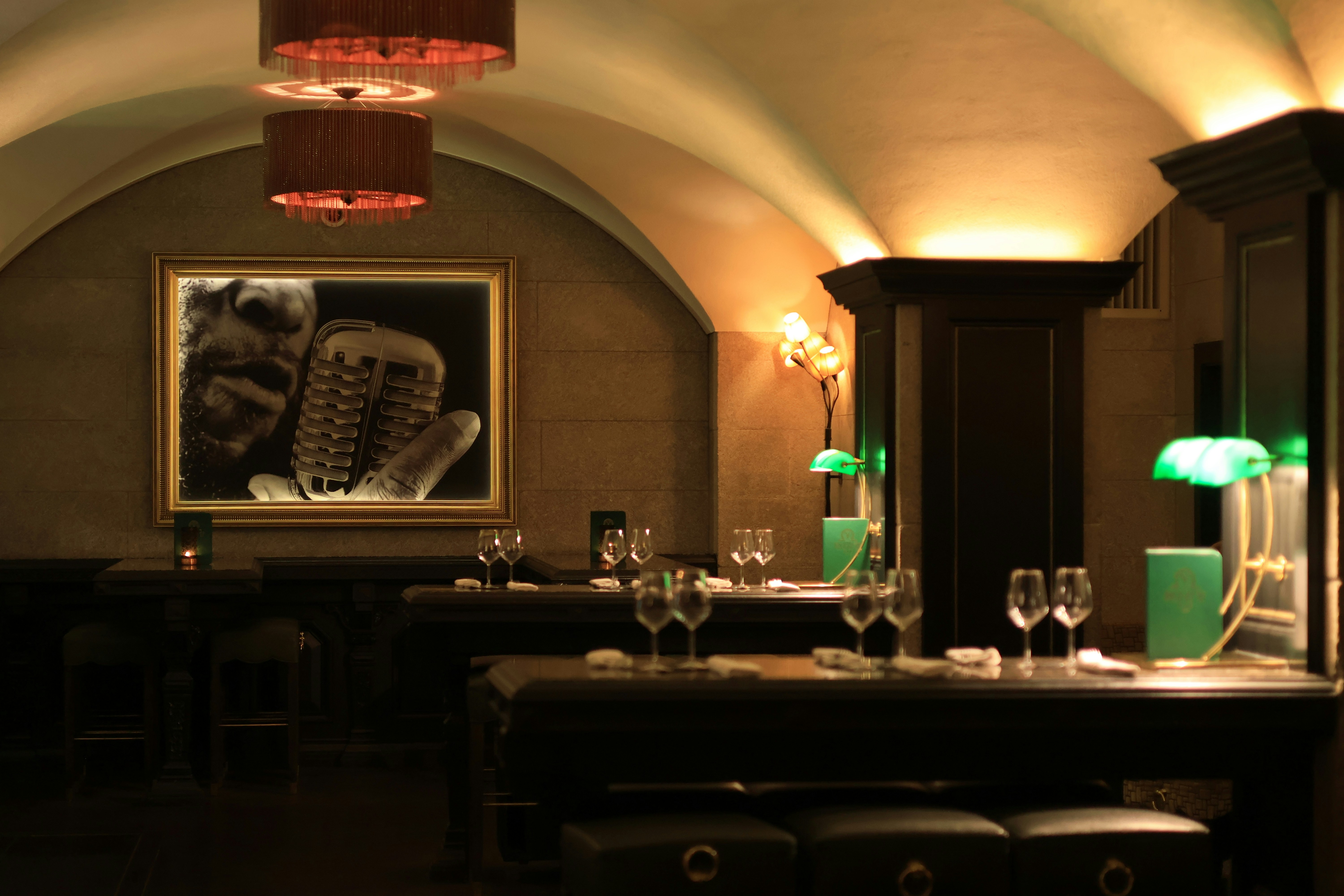 Quiet Jazz Lounge: A Warm Atmosphere Framed by Bar, Portrait, and Green Banker Lamps