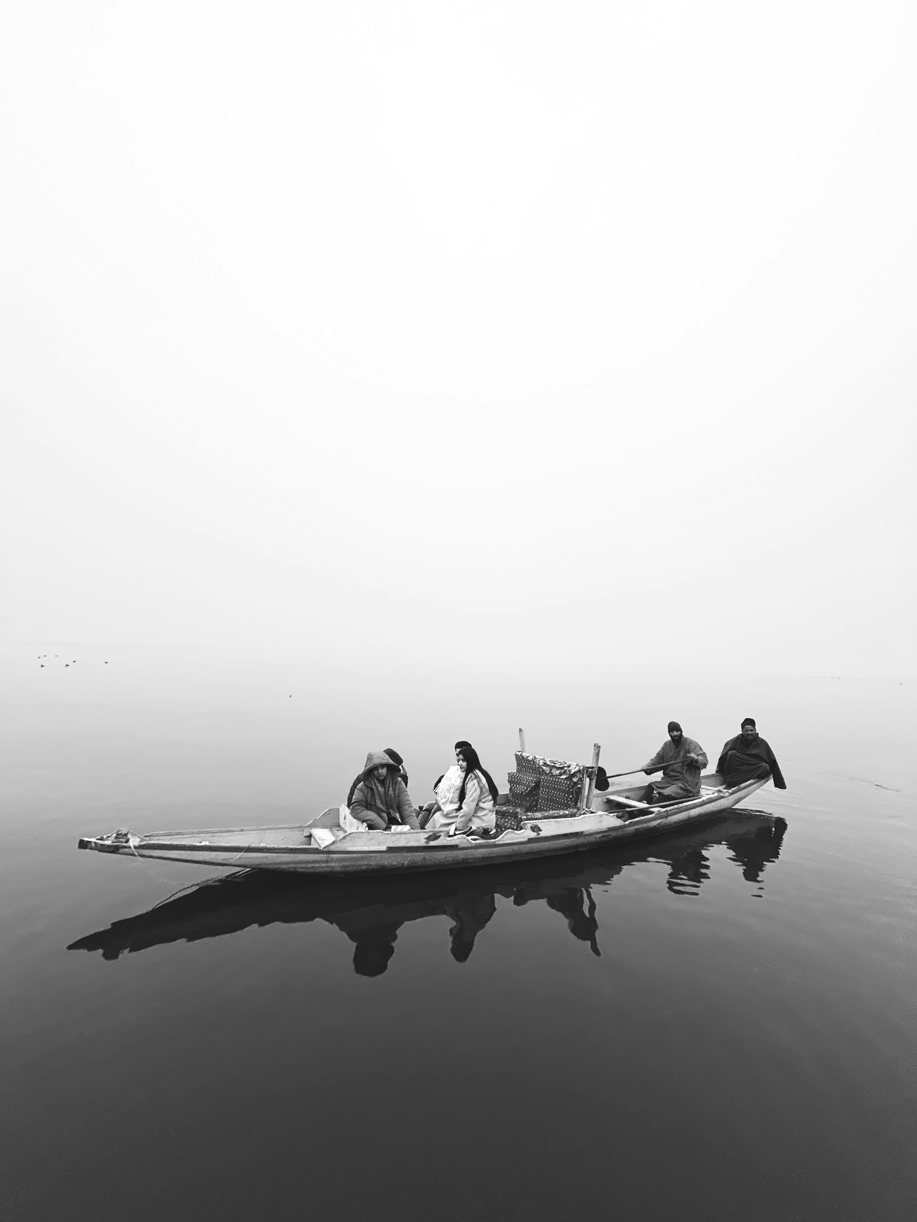 Silhouette on Still Waters: A Boat of Travelers Adrift in Mist