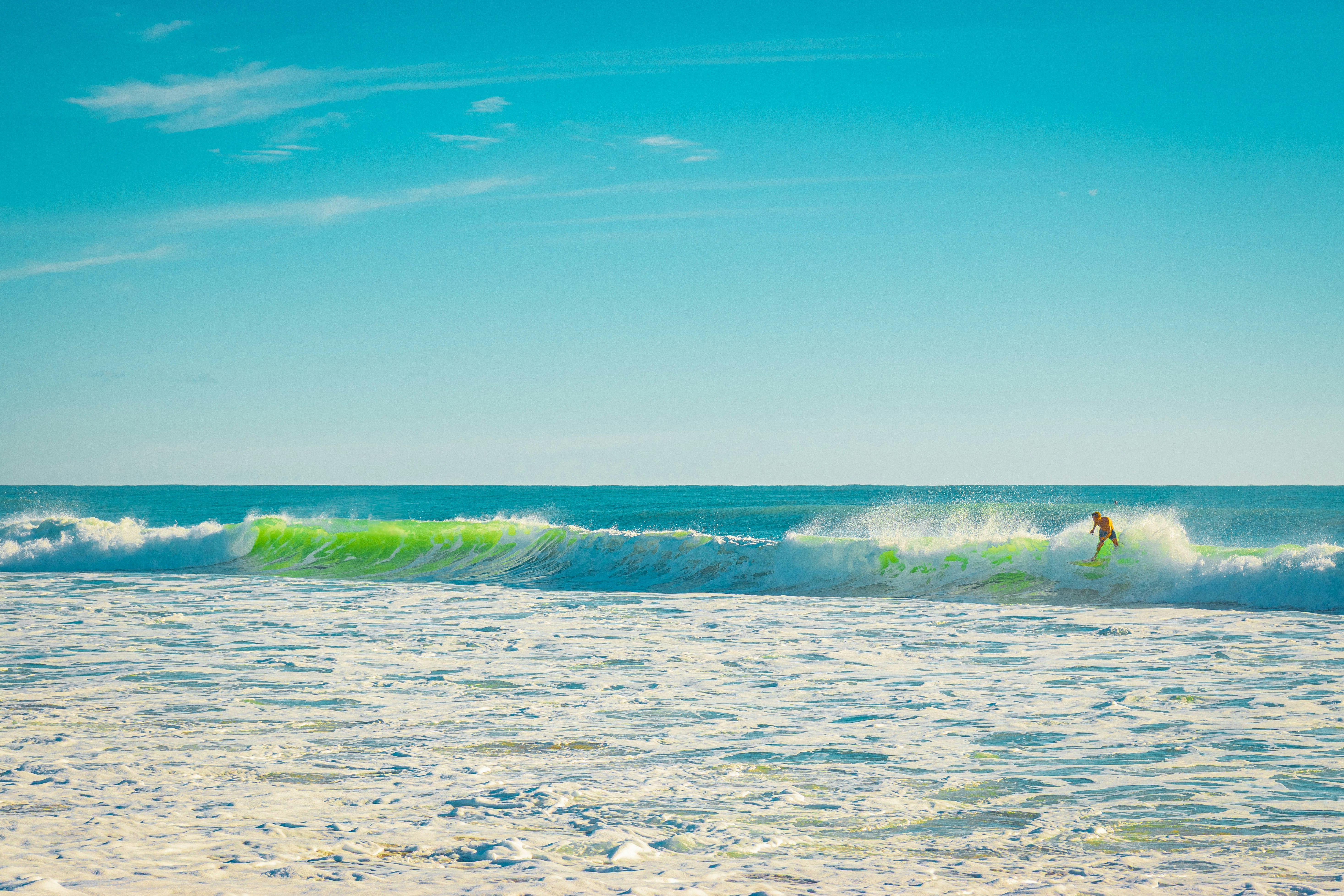 Surfline Echo: A Single Surfer Riding a Crest Under a Wide Ocean Sky