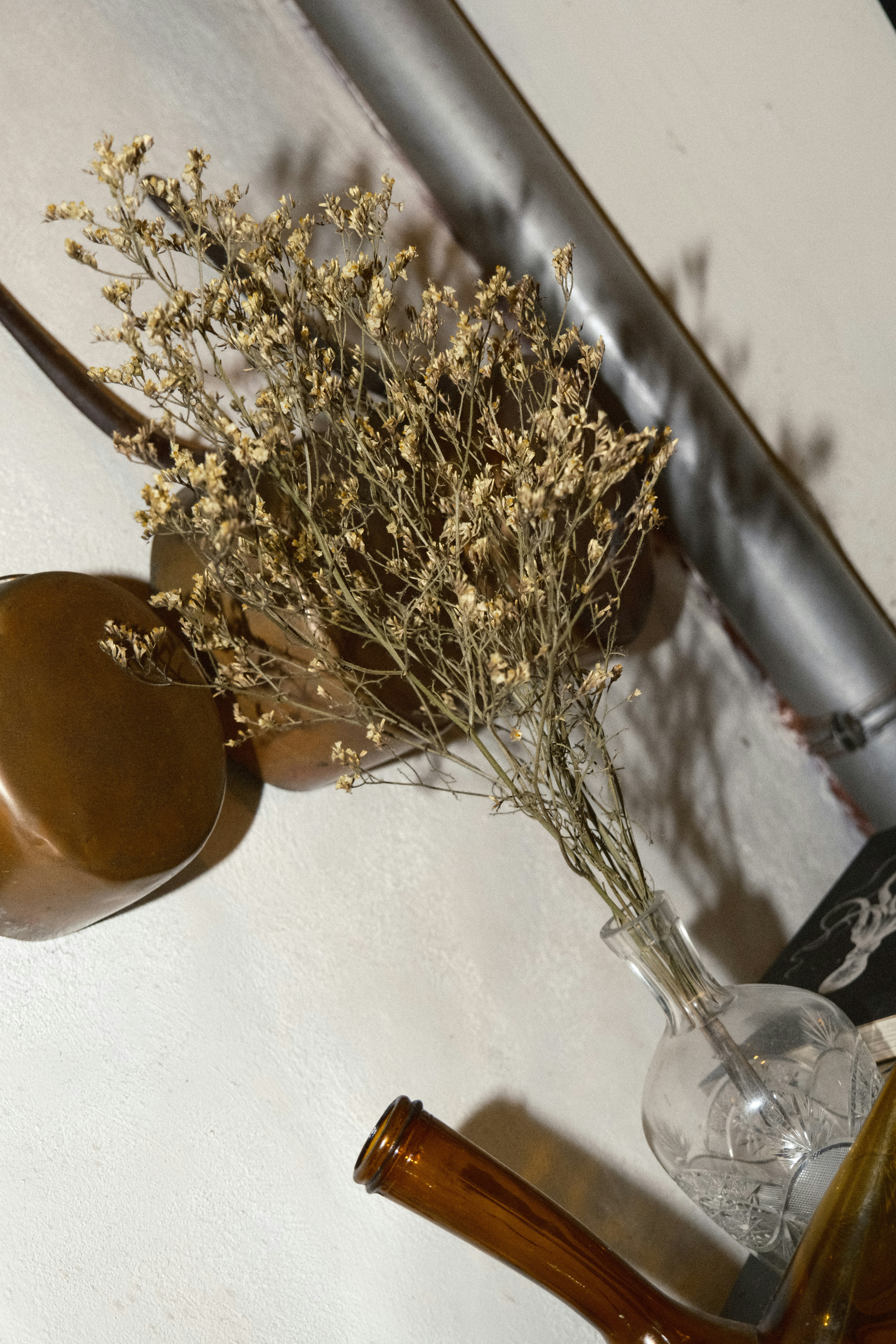 Dry Bouquet in a Glass Bottle: A Tilted Still-Life with Amber Bottles