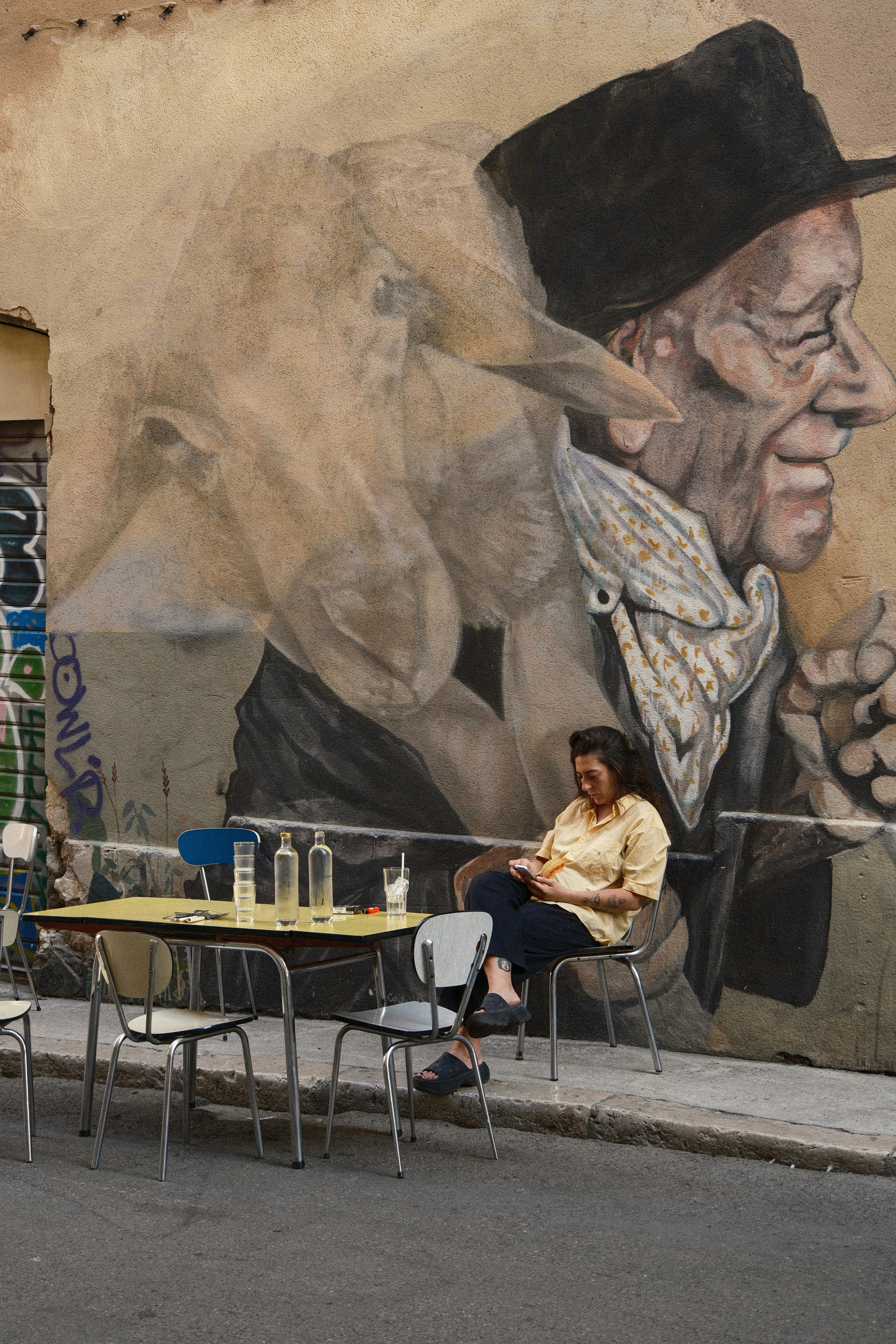 Whispers of a Sidewalk Portrait: A Quiet Moment Amid a Grand Mural