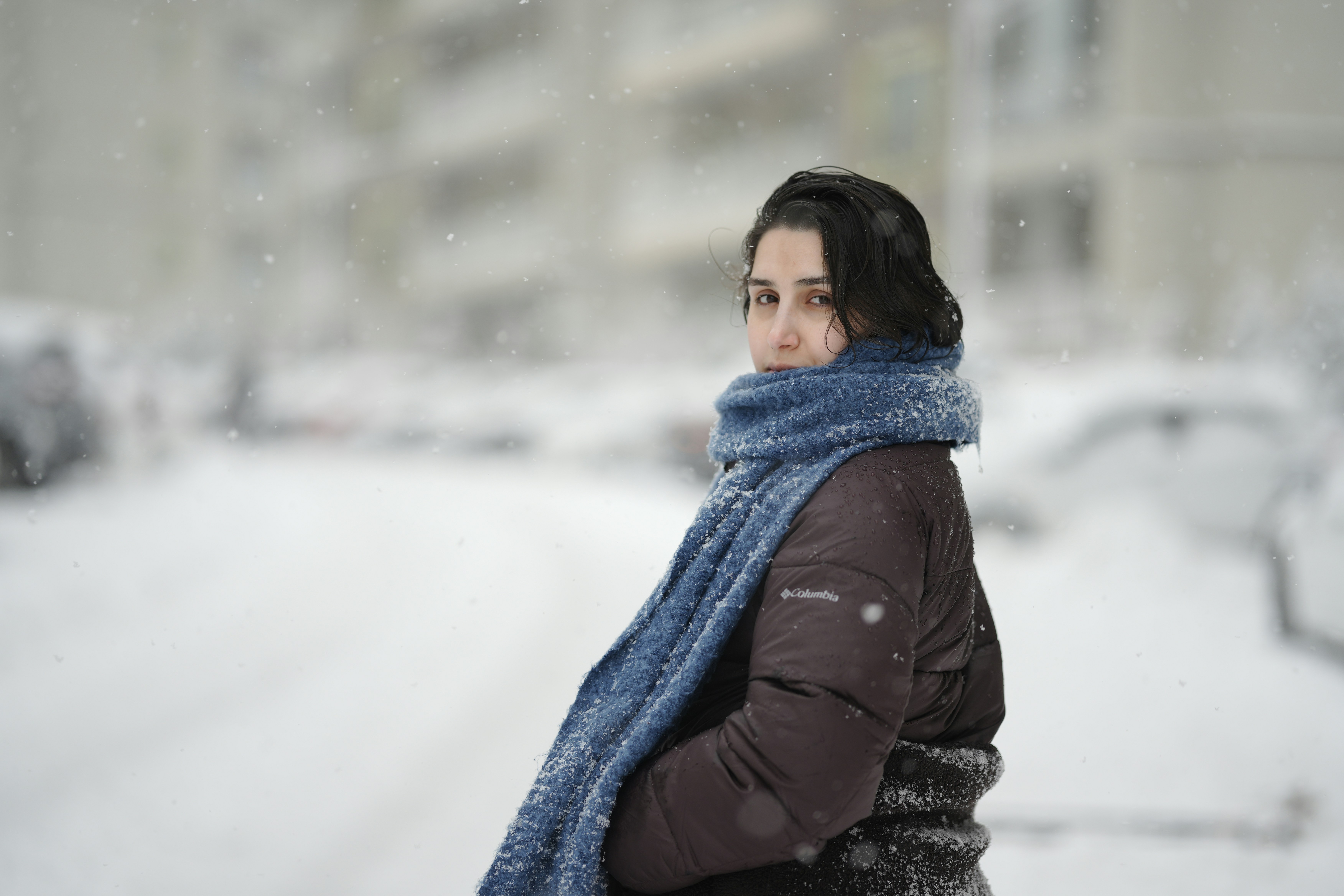 Snowy Street Portrait: A Moment Warmed by a Blue Scarf