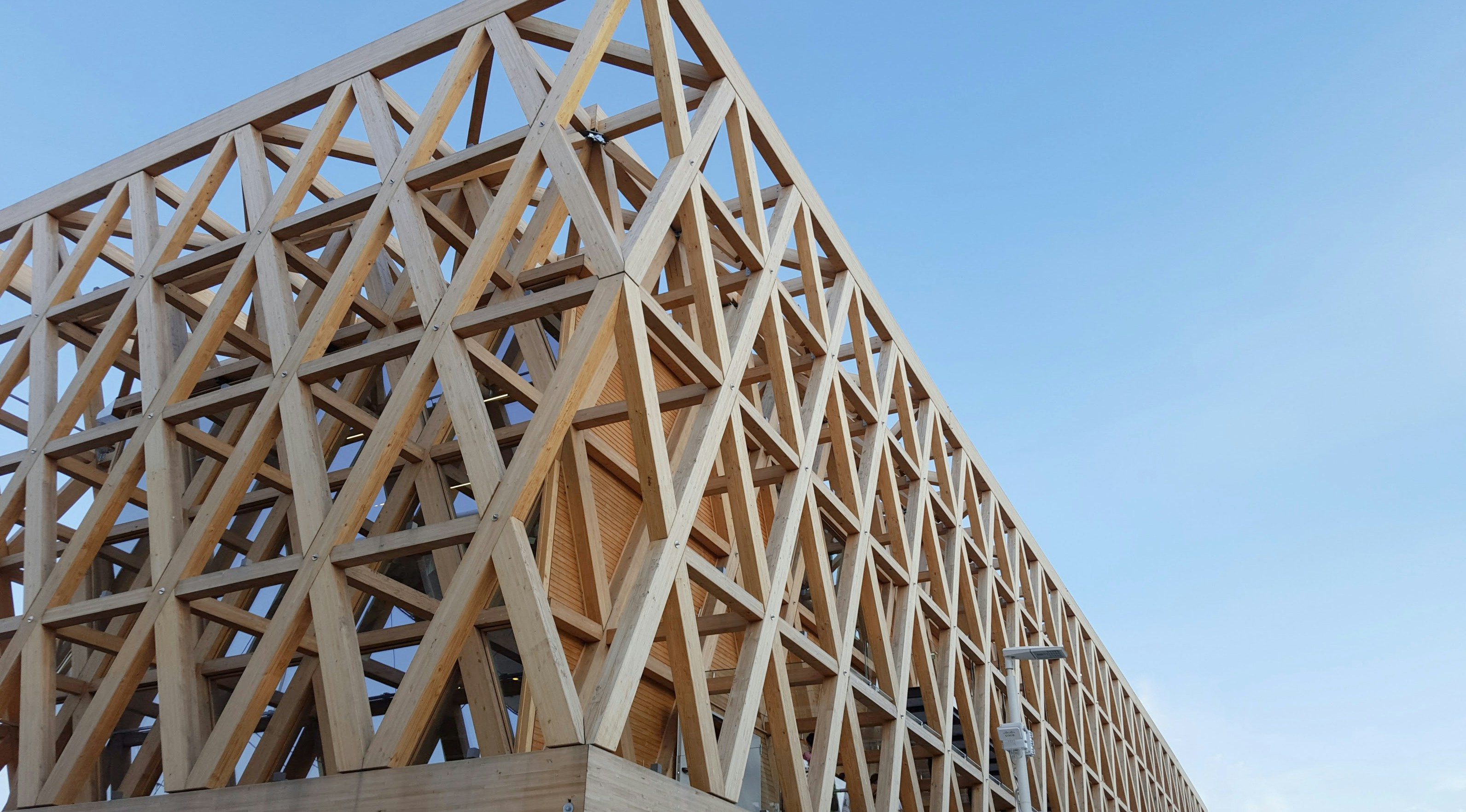 Geometric Timber Grid Soars Against a Clear Sky