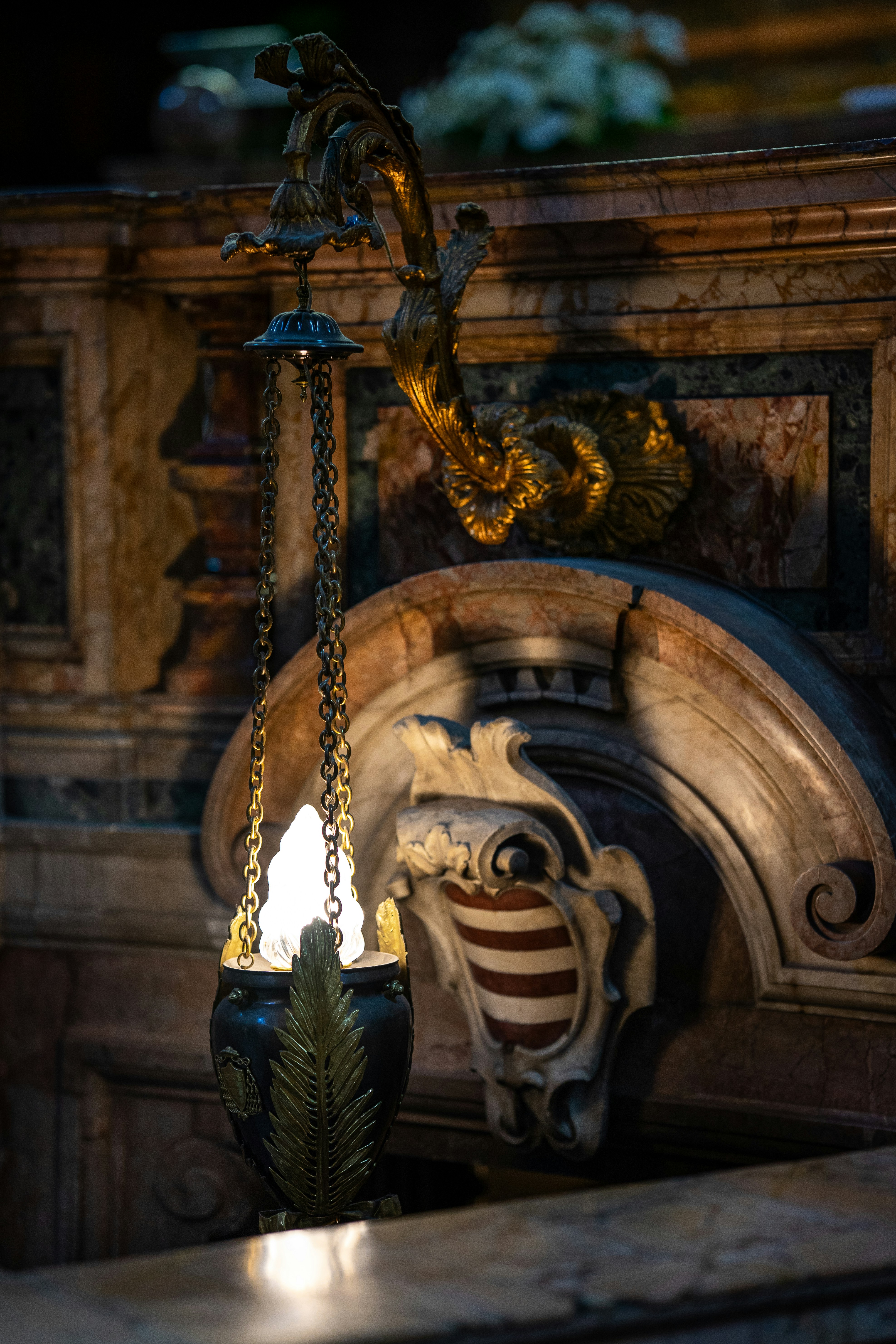 Ornate Fountain Flame: A Lantern Beside Marble Carving
