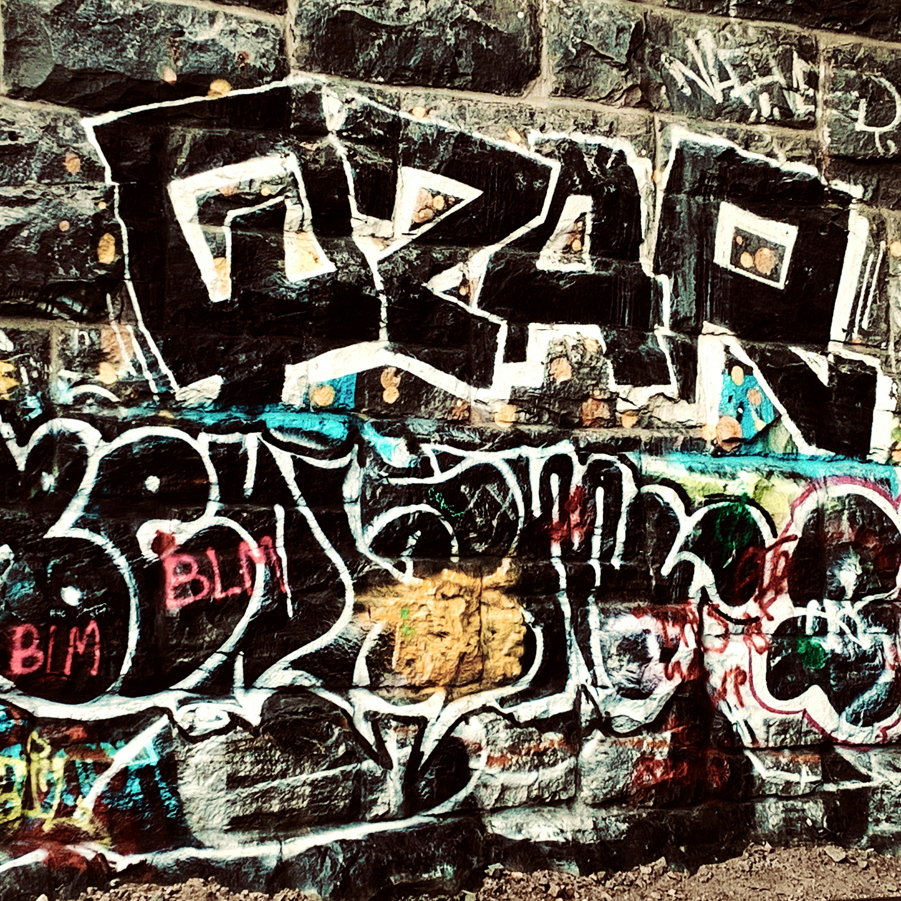Underpass Echoes: A Maze of Graffiti on Weathered Brick