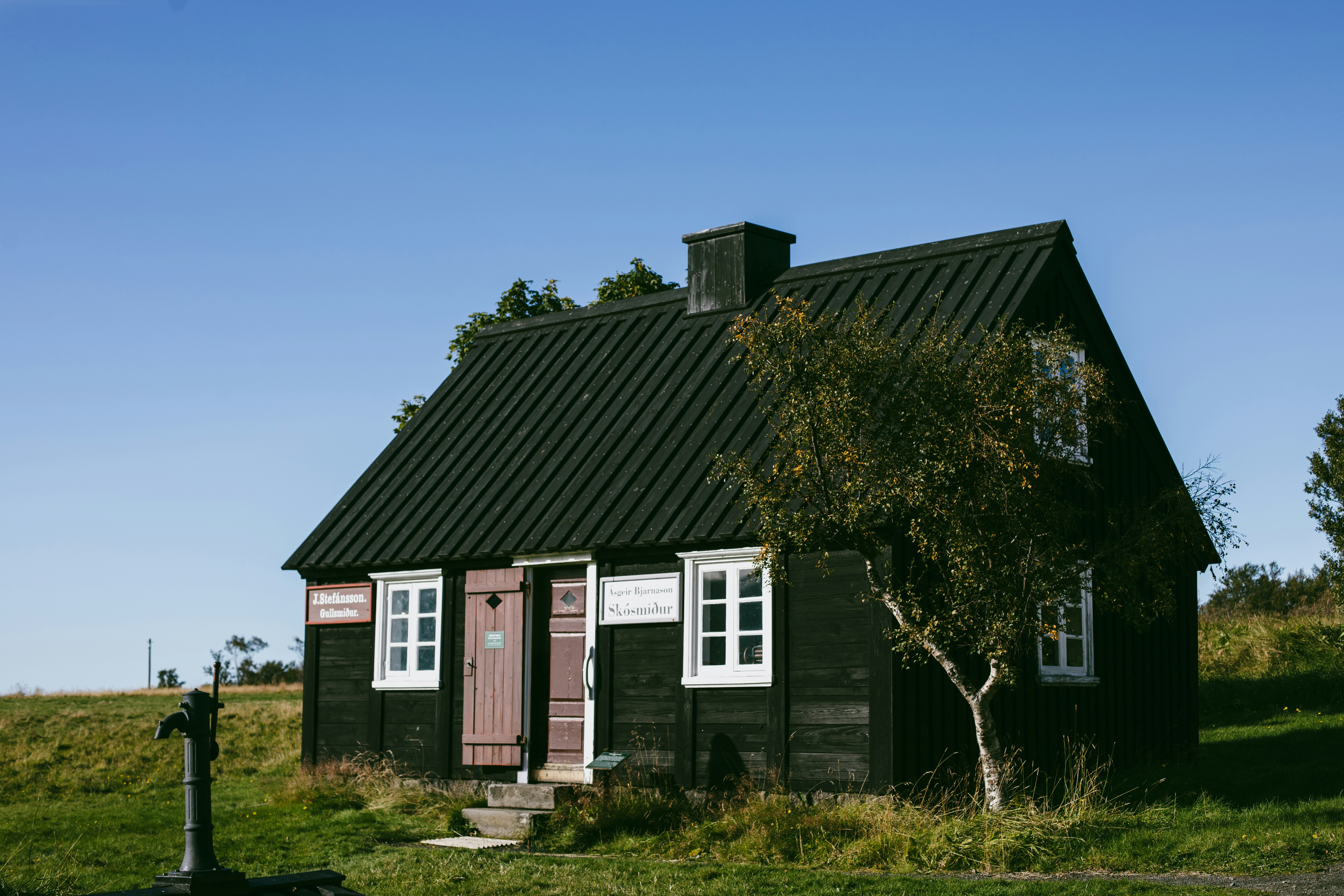 Cottage in a Sunlit Field with a Tree Shadow