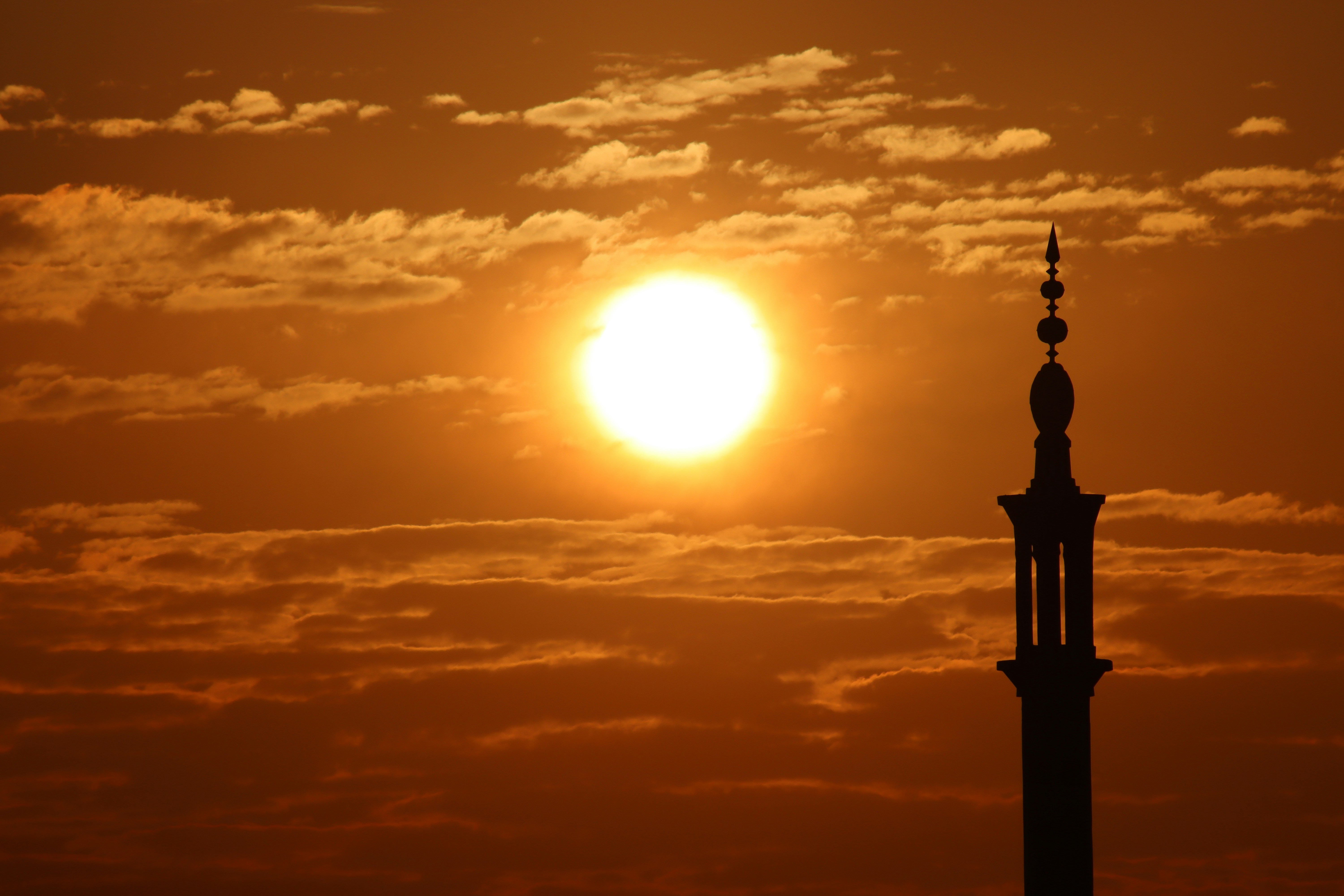 Sunlit Skyline: Silhouette of a Minaret Against a Golden Dusk