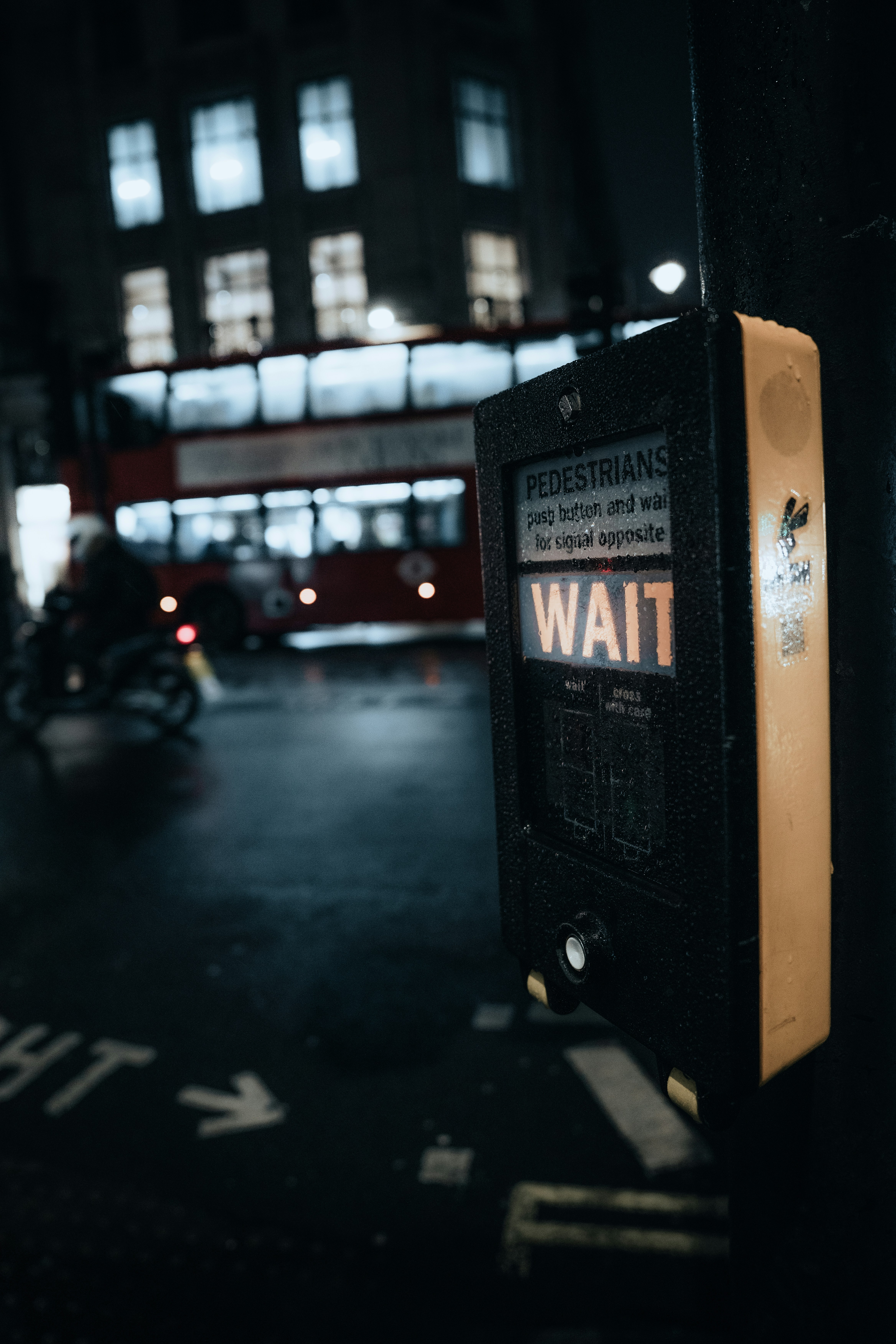 Neon Wait Sign at a Rainy City Crosswalk