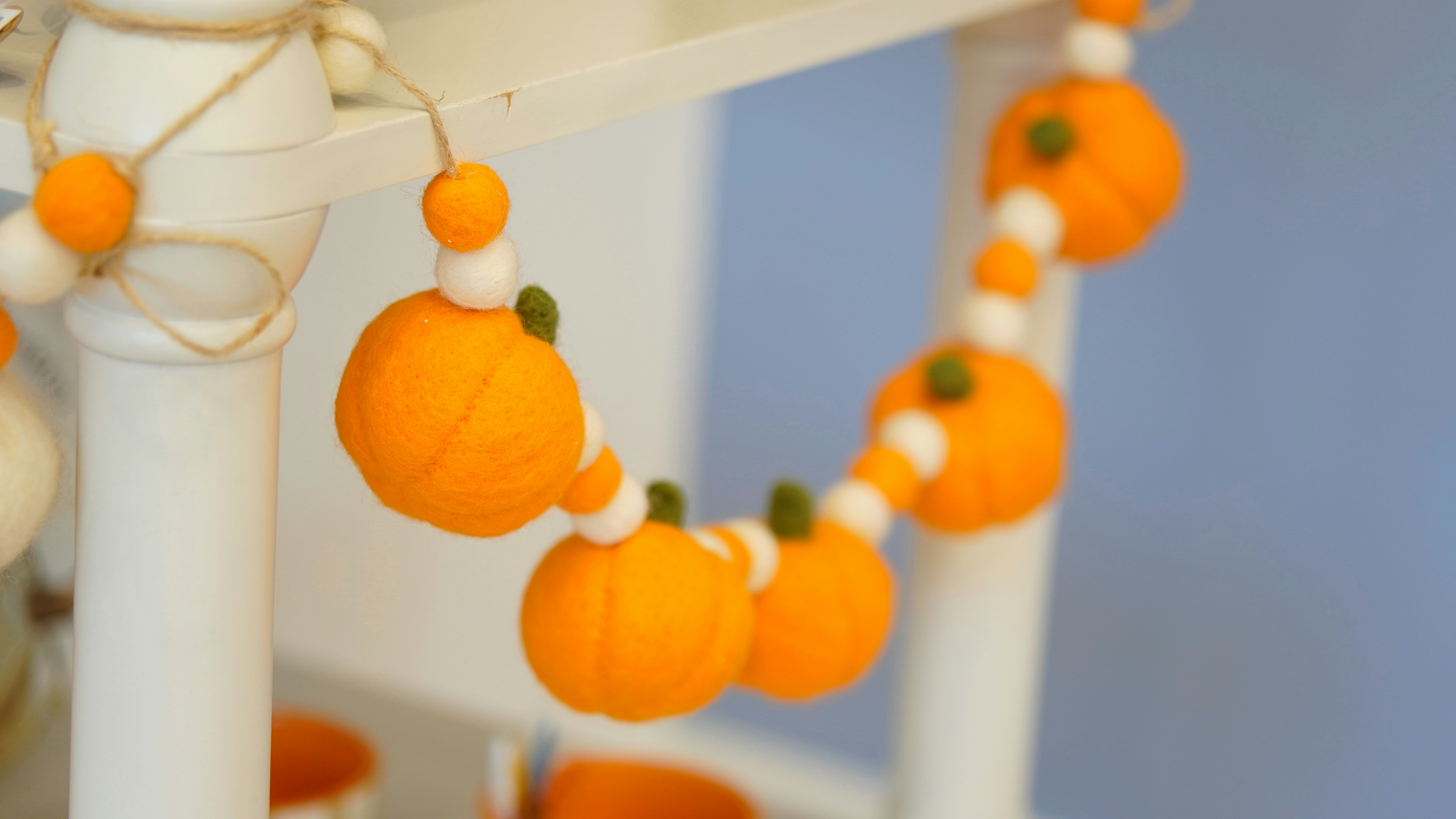Tiny Orange Garlands Draped Across a White Frame