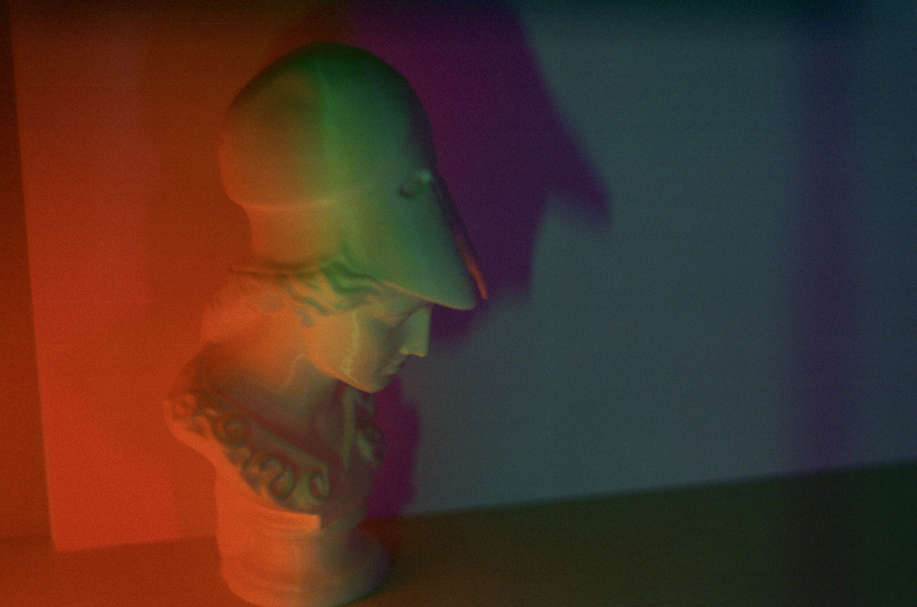 Colored silhouettes of a bust under layered neon light